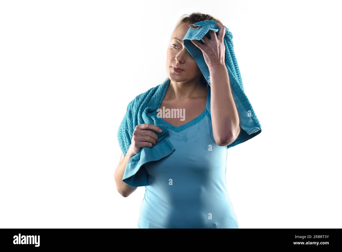 Single slim woman in blue tights wiping sweat on her head with towel ...