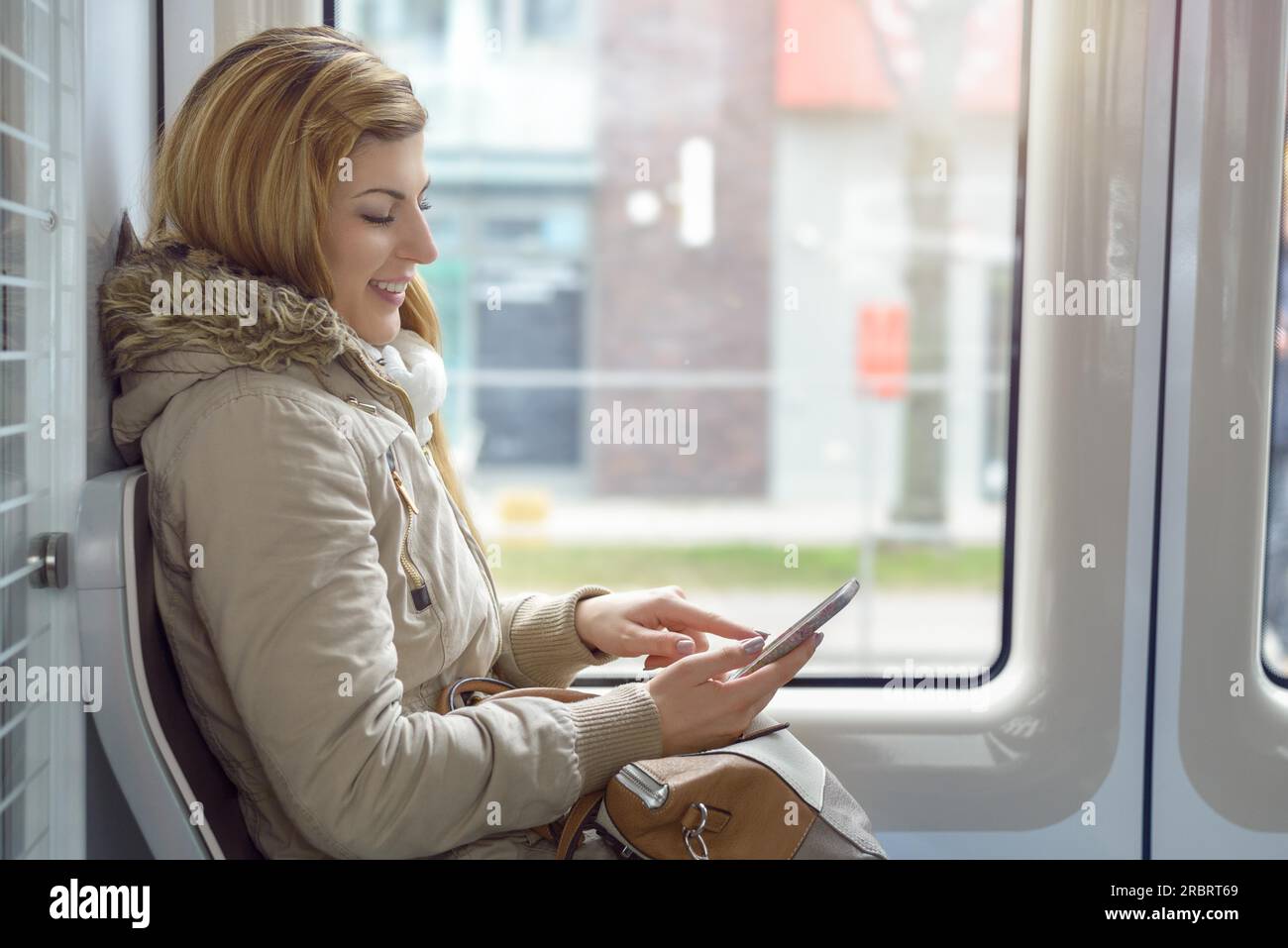 Attractive young woman riding as a passenger in a train sitting ...