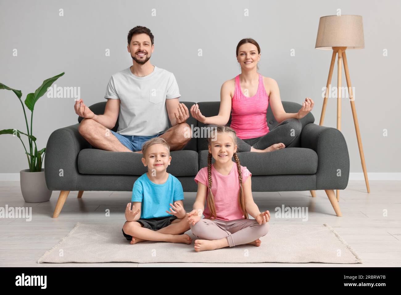 Happy family meditating together at home. Harmony and zen Stock Photo ...