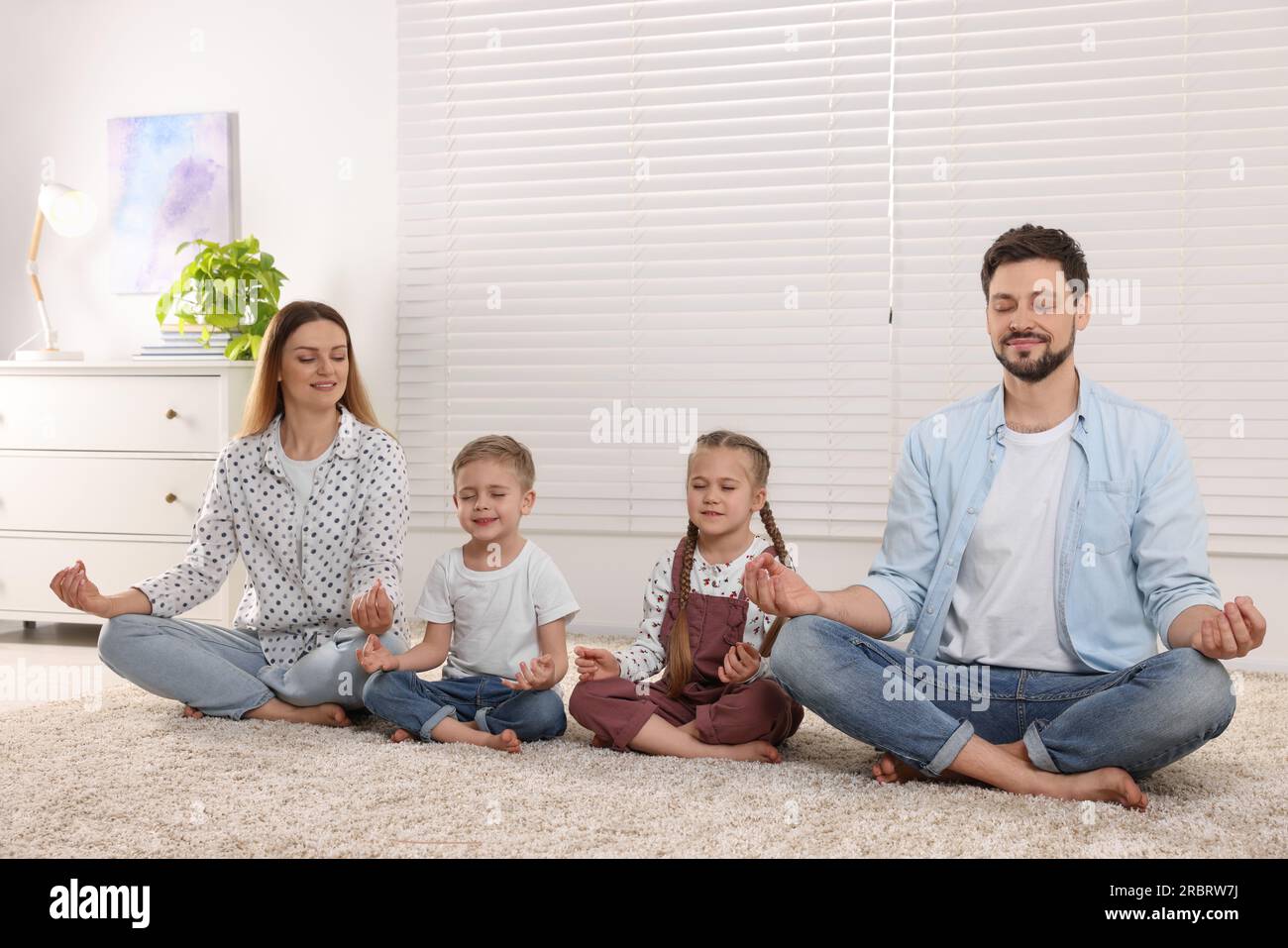 Family meditating together at home. Harmony and zen Stock Photo - Alamy