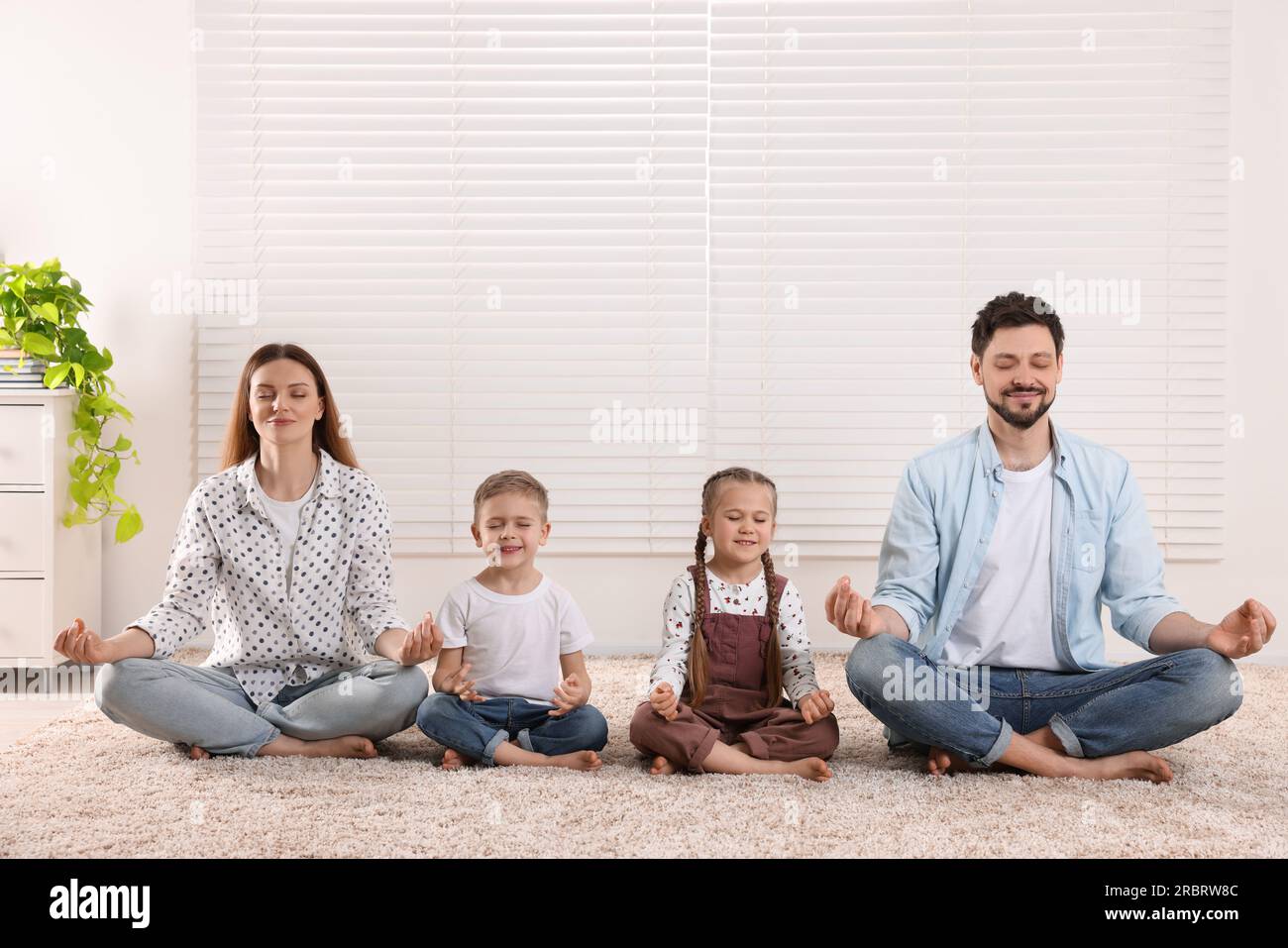 Family meditating together at home. Harmony and zen Stock Photo - Alamy