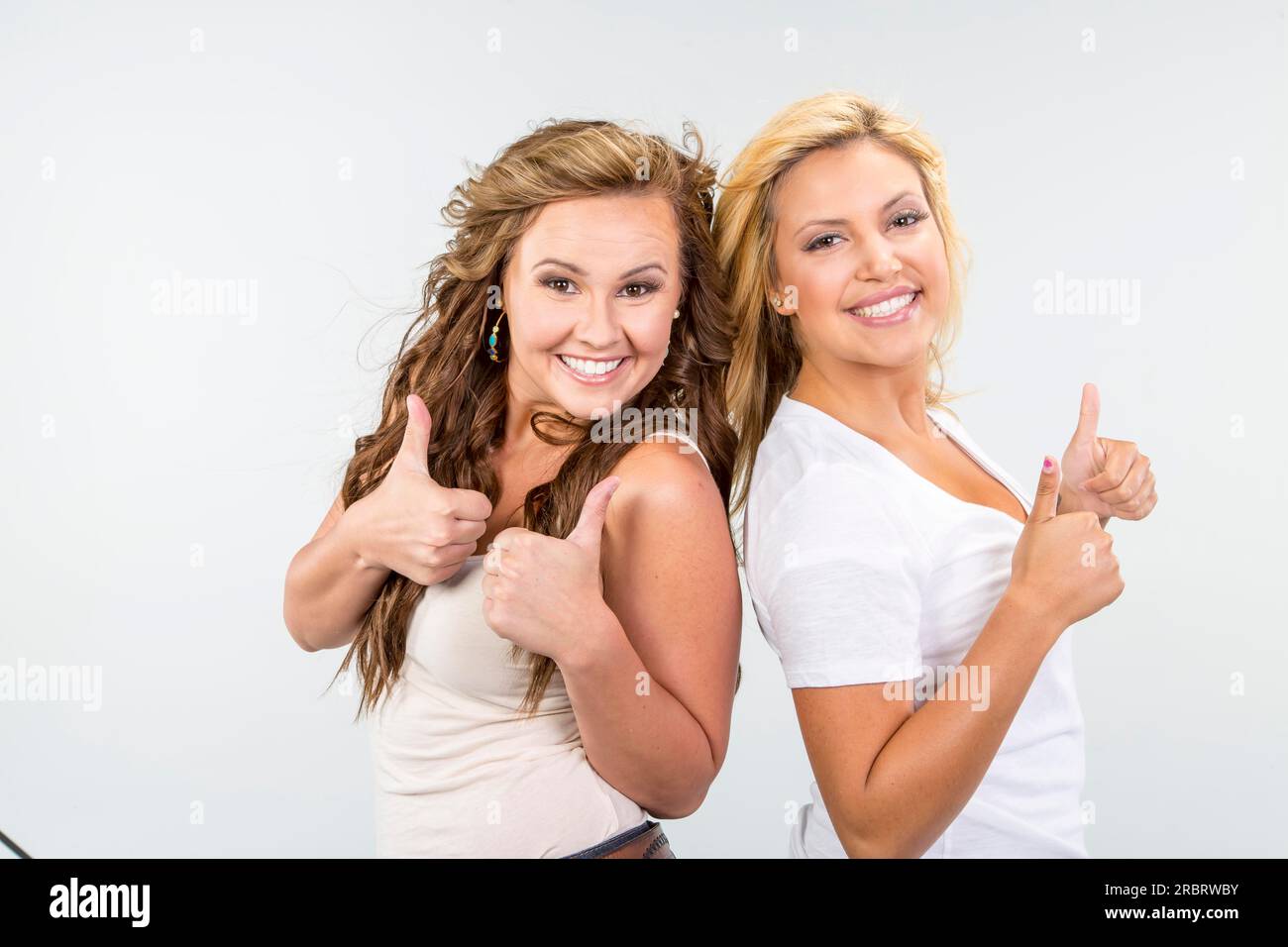 Two female friends showing affection to each other in a studio ...