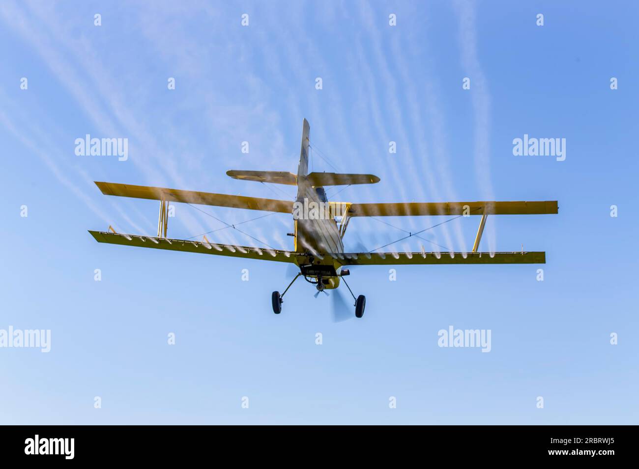 A crop duster applies chemicals to a field of vegetation Stock Photo ...