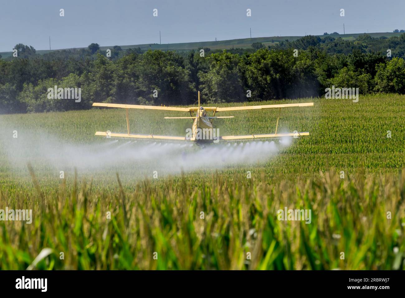 A crop duster applies chemicals to a field of vegetation Stock Photo ...