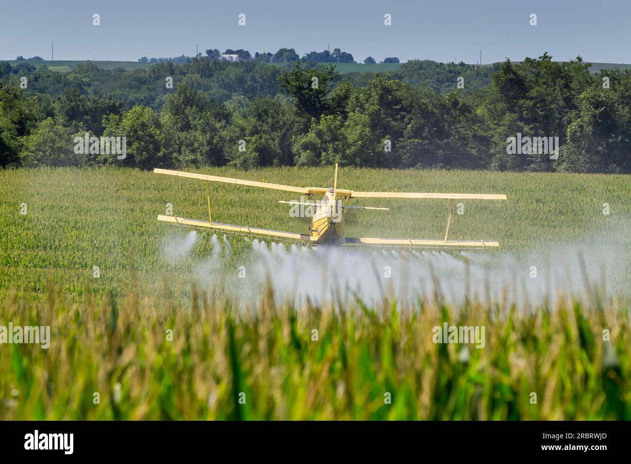 A crop duster applies chemicals to a field of vegetation Stock Photo ...