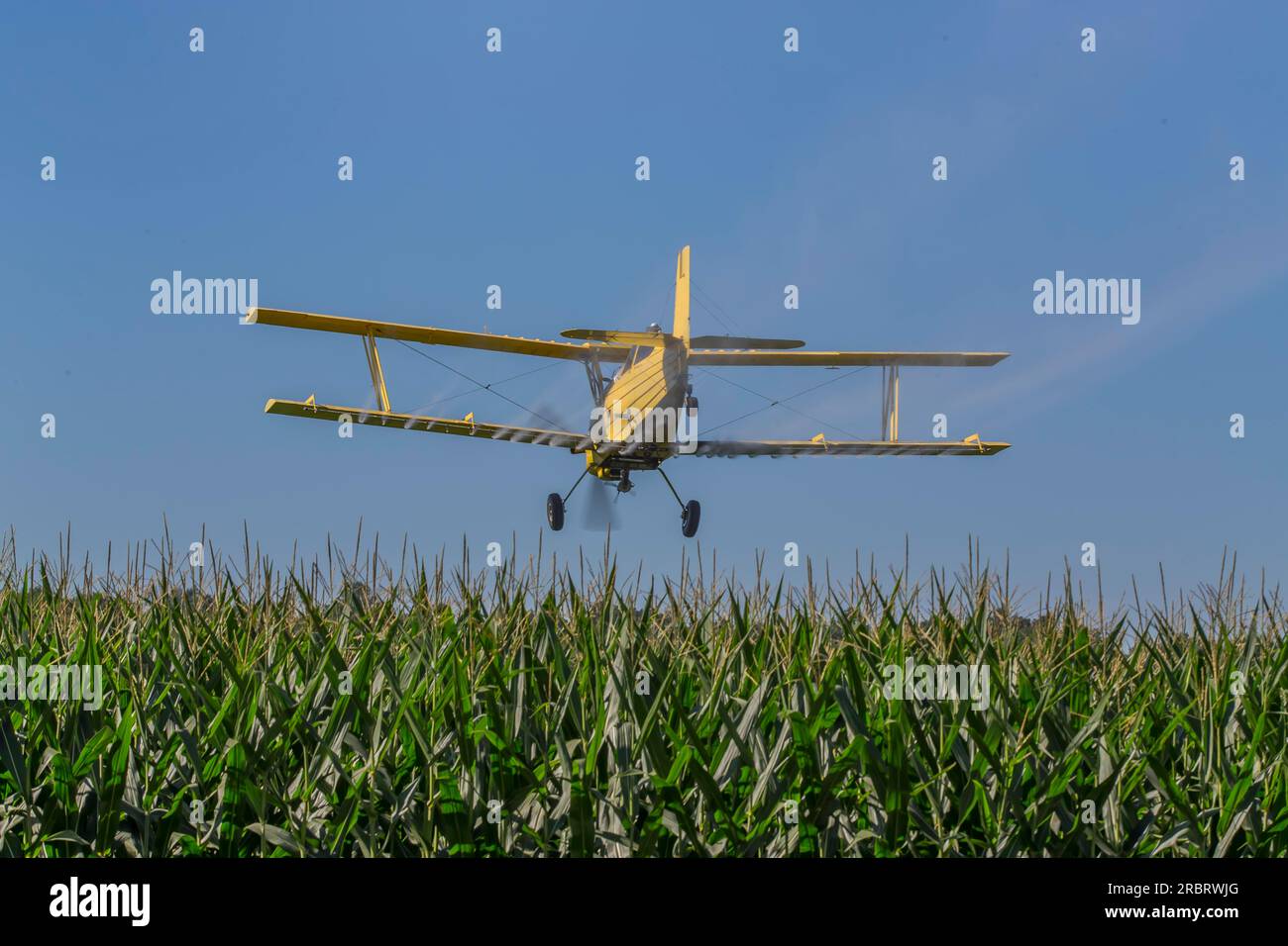 A crop duster applies chemicals to a field of vegetation Stock Photo ...