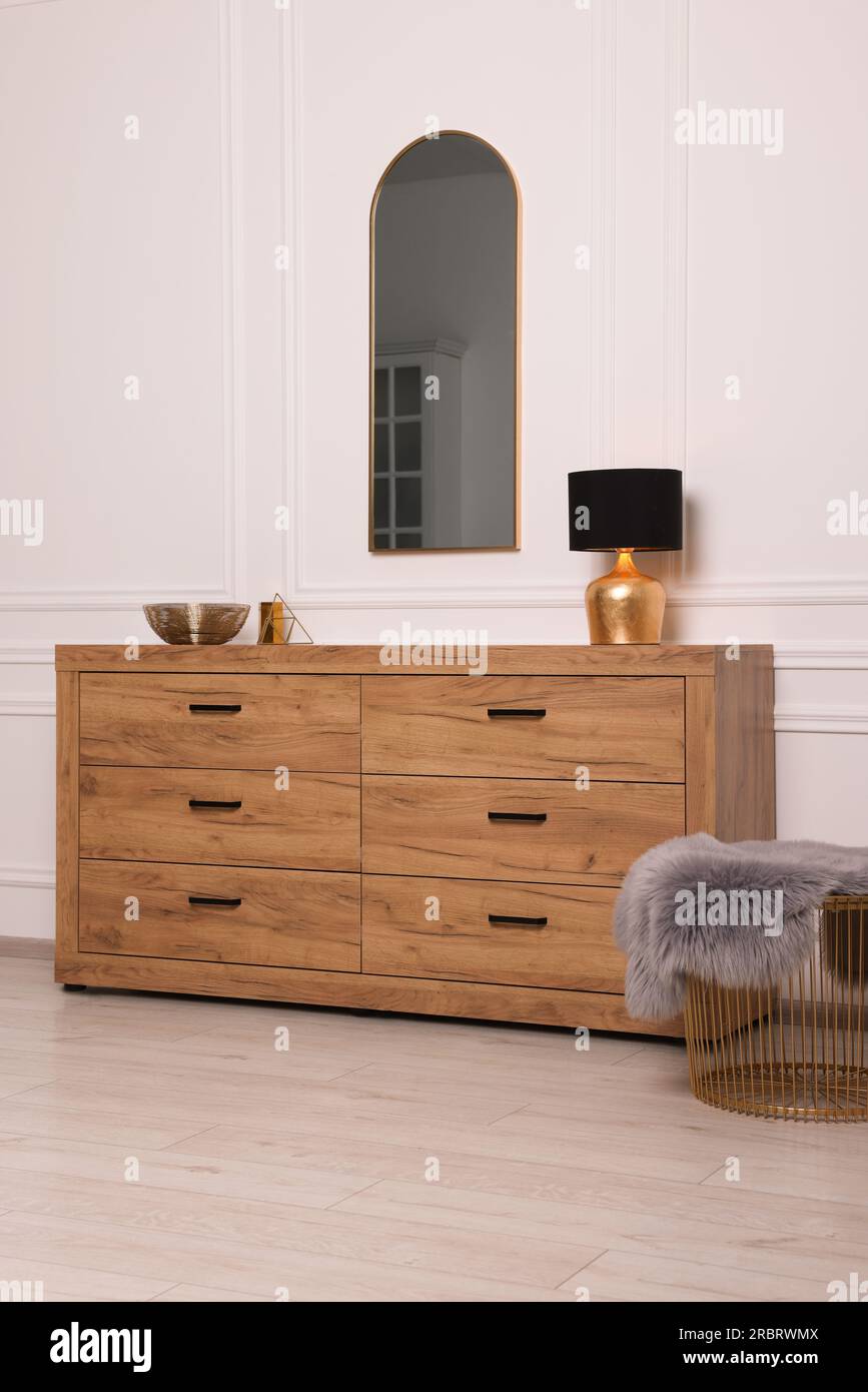 Stylish room interior with chest of drawers, mirror and decor elements ...
