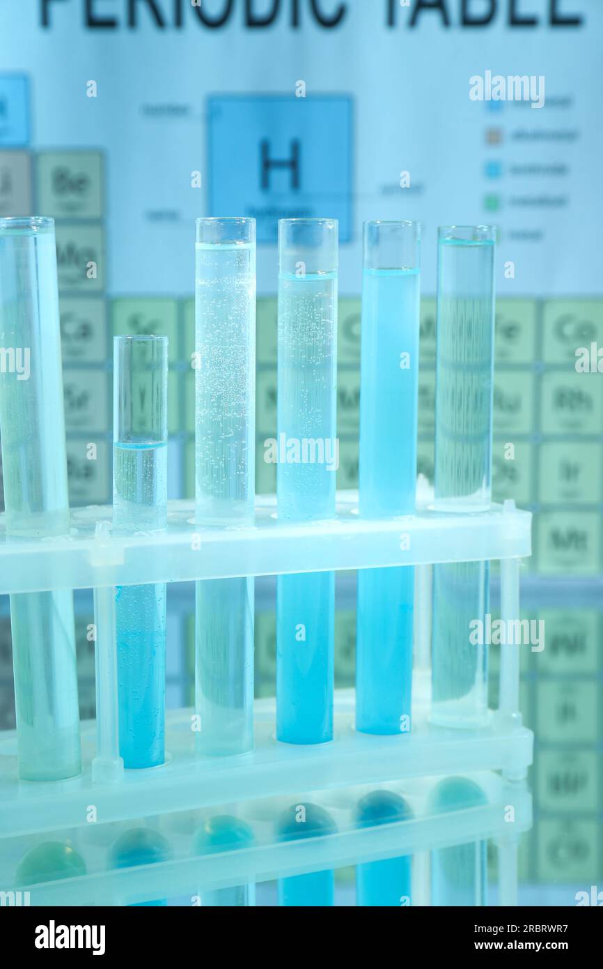 Test tubes in rack on mirror surface against periodic table of chemical ...