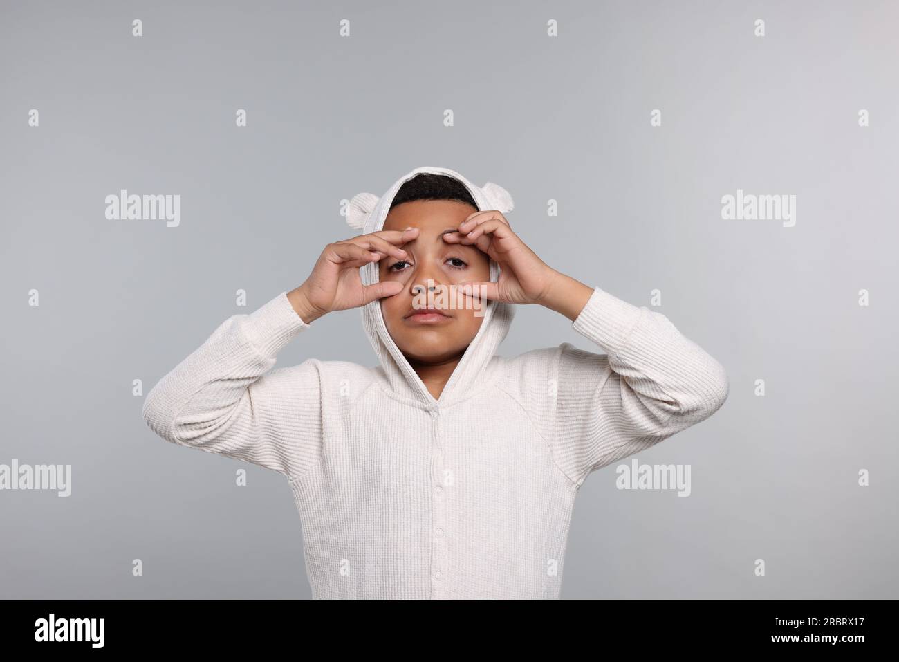 Sleepy boy in pajama on grey background. Insomnia problem Stock Photo ...