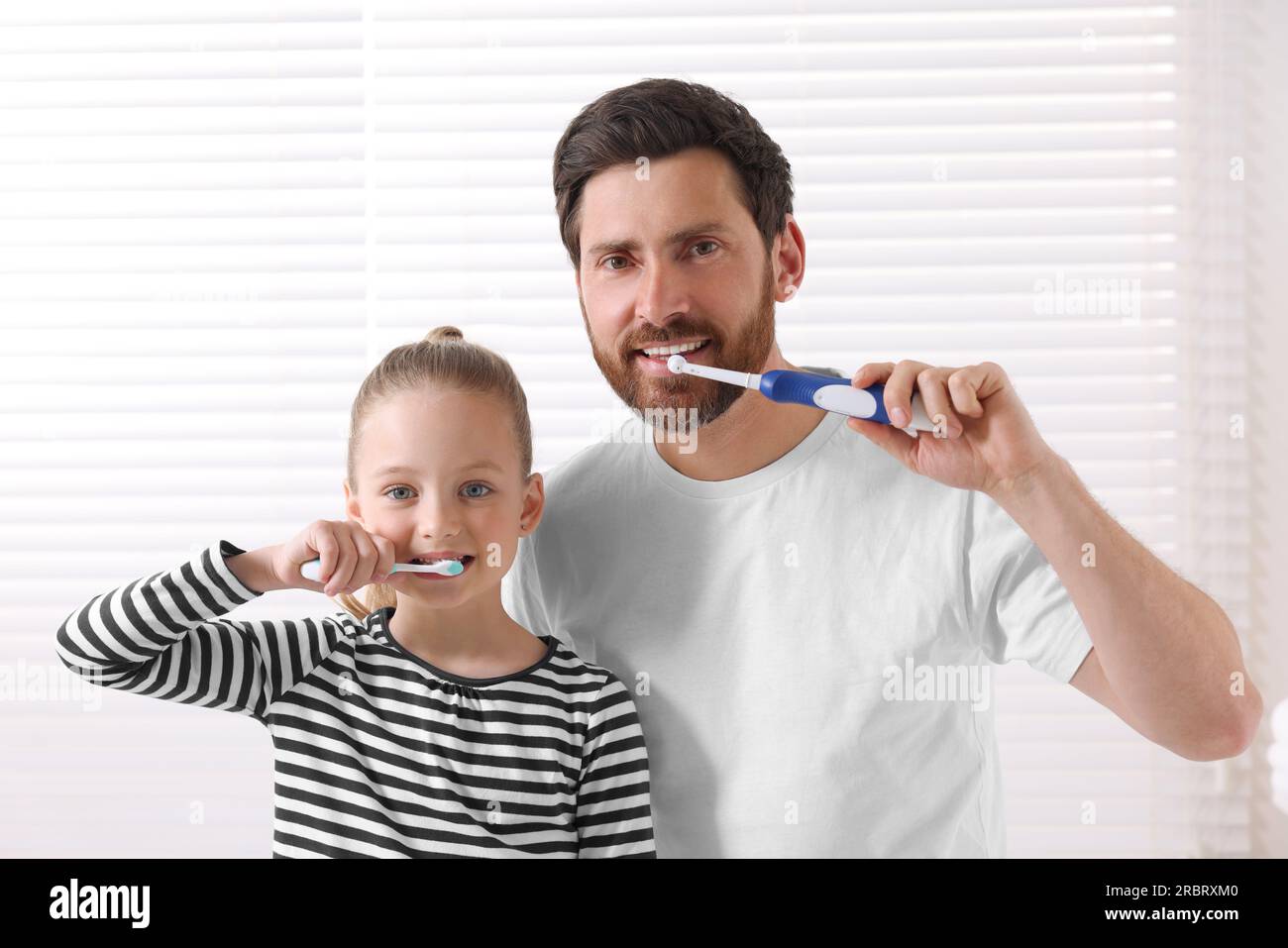 Father and his daughter brushing teeth together indoors Stock Photo - Alamy