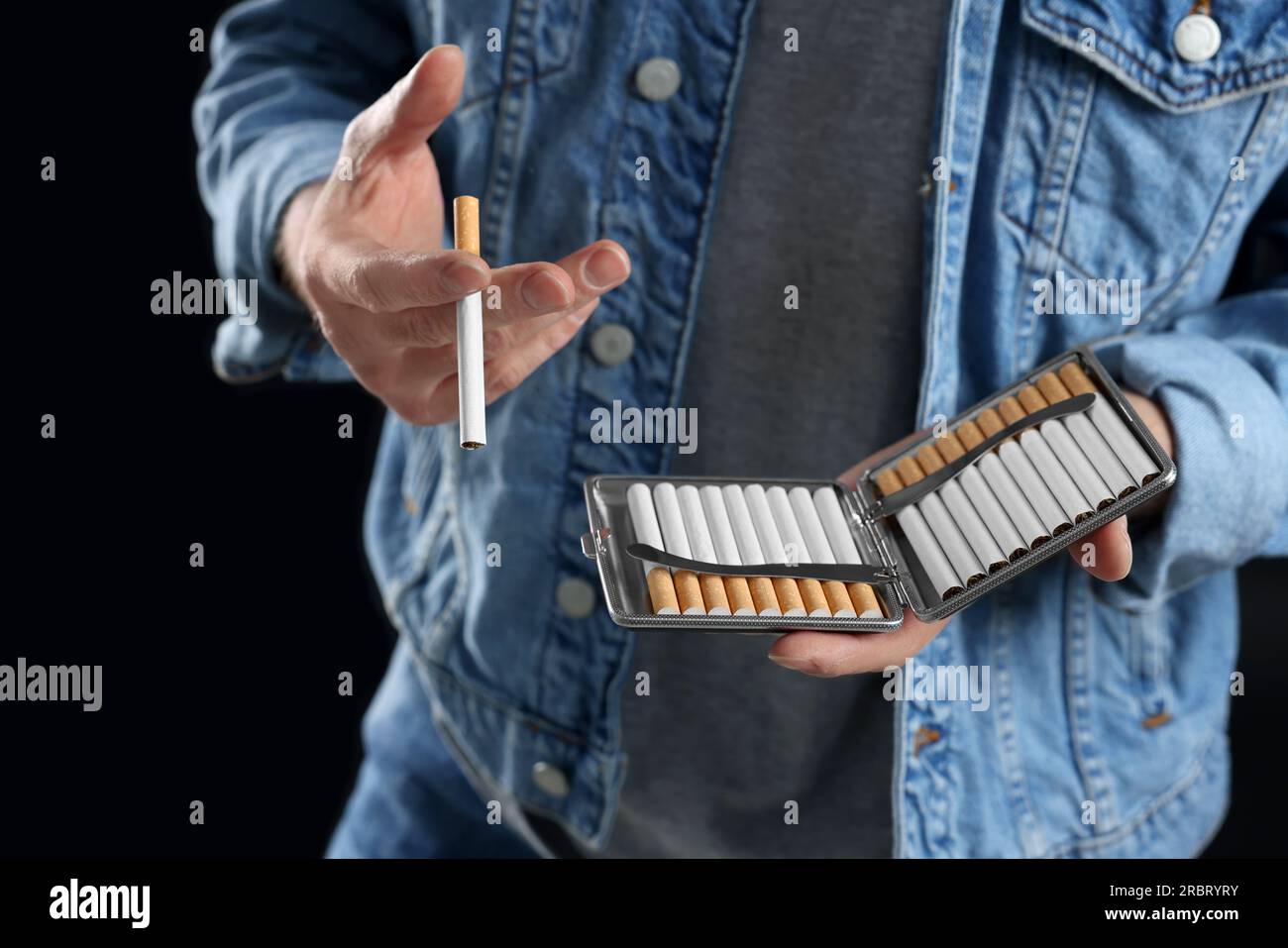 Man taking cigarette from case on black background, closeup Stock Photo ...