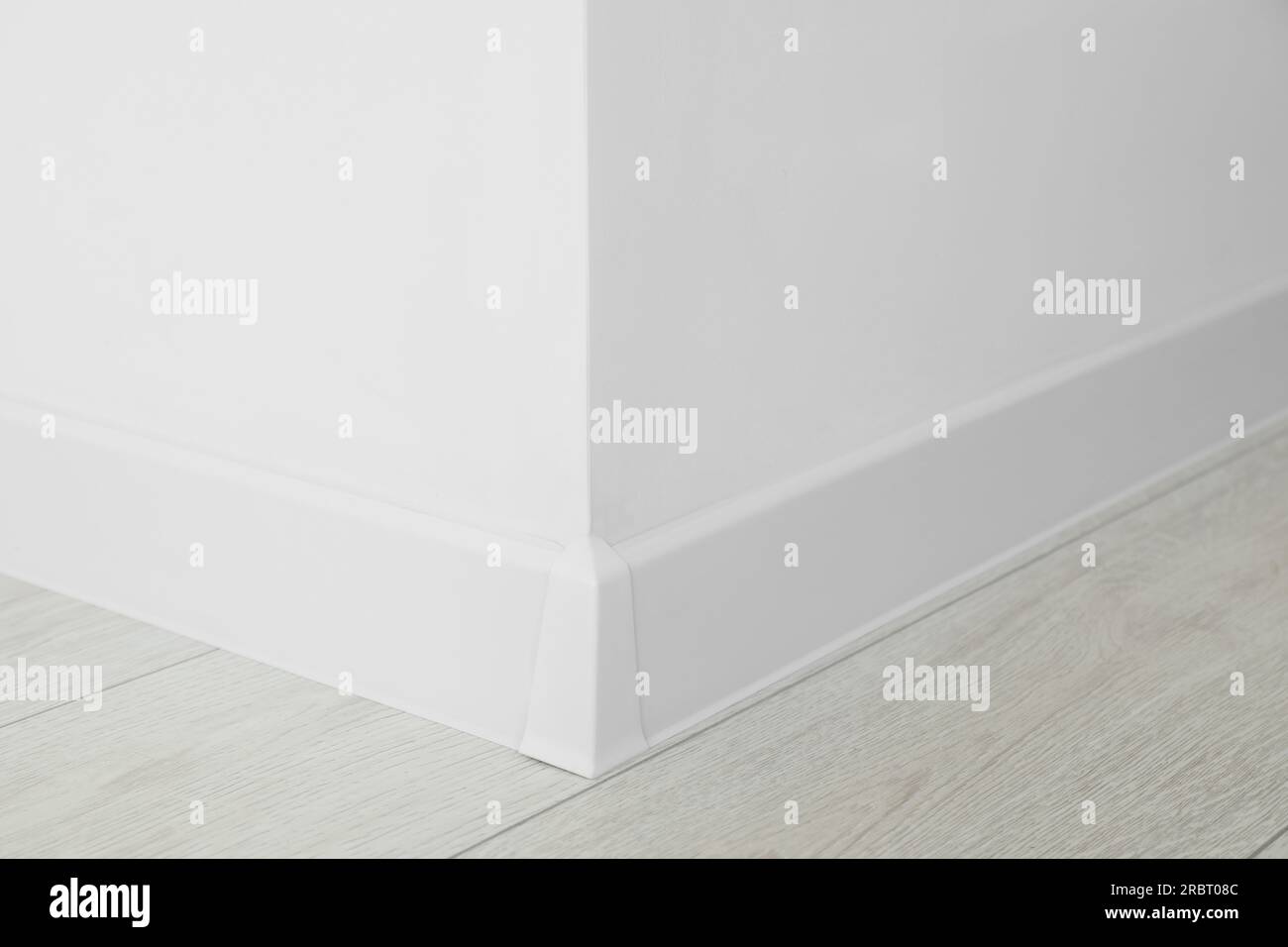 White plinth with connector on laminated floor near wall indoors ...
