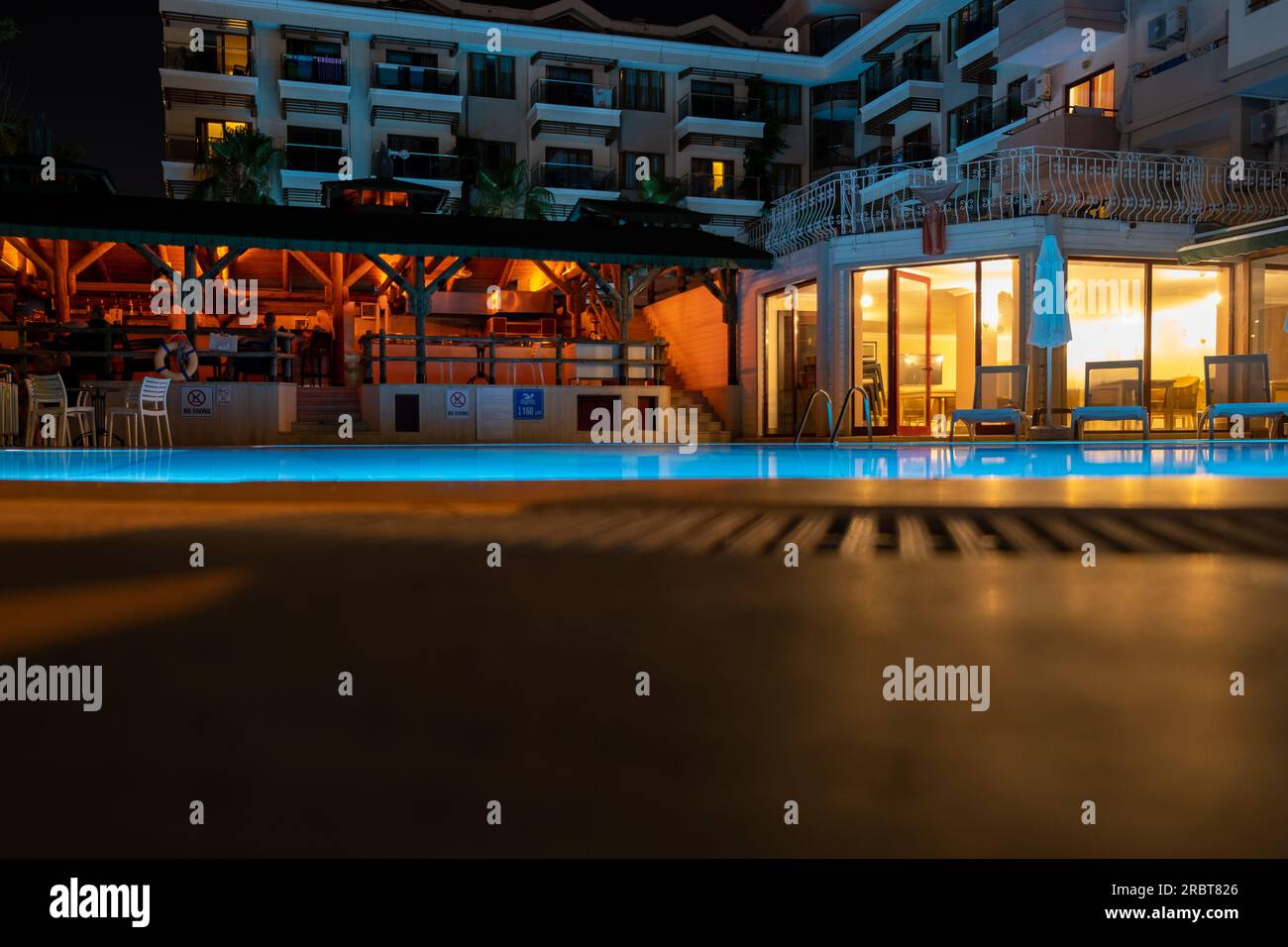 Beautiful hotel illuminated at night near the blue pool Stock Photo - Alamy