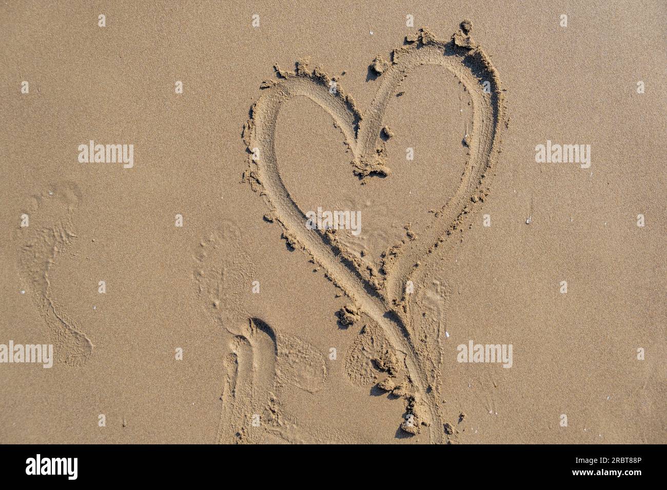 Heart shape and footprint on wet sand Stock Photo - Alamy