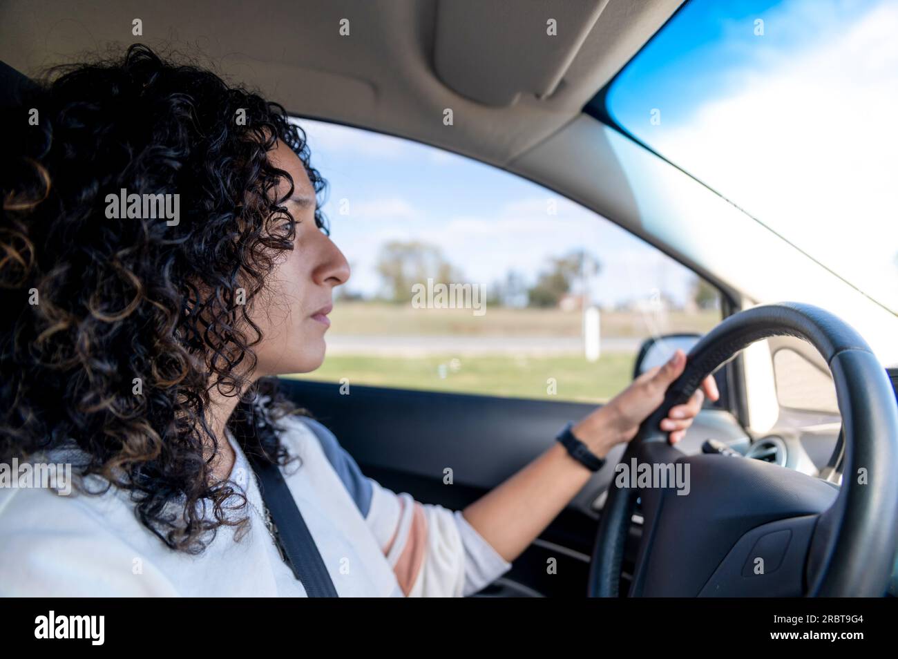 Young serious woman driving a car on the road Stock Photo - Alamy