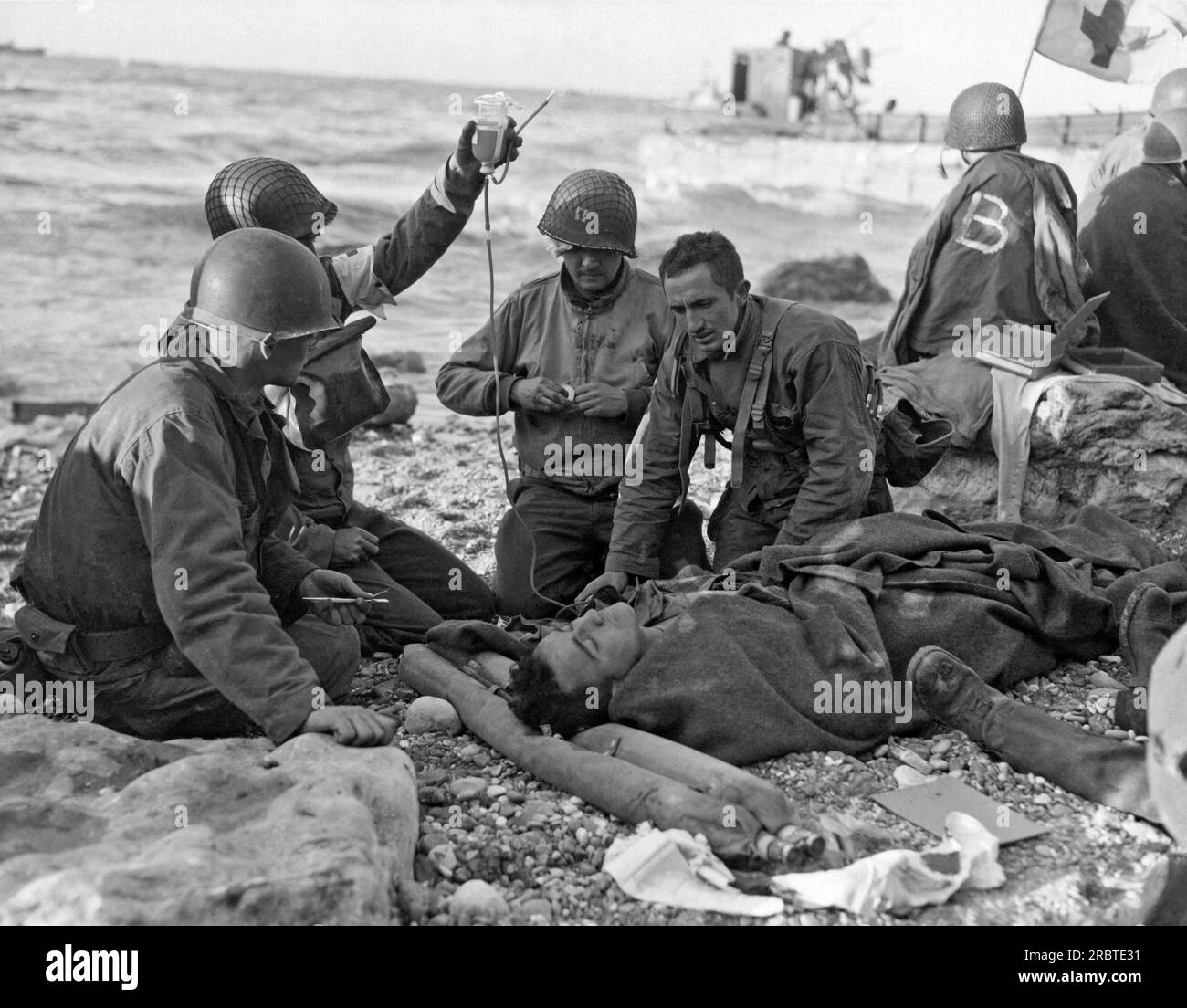 Normandy, France: June 7, 1944. Medics gving plasma on the beach to a ...