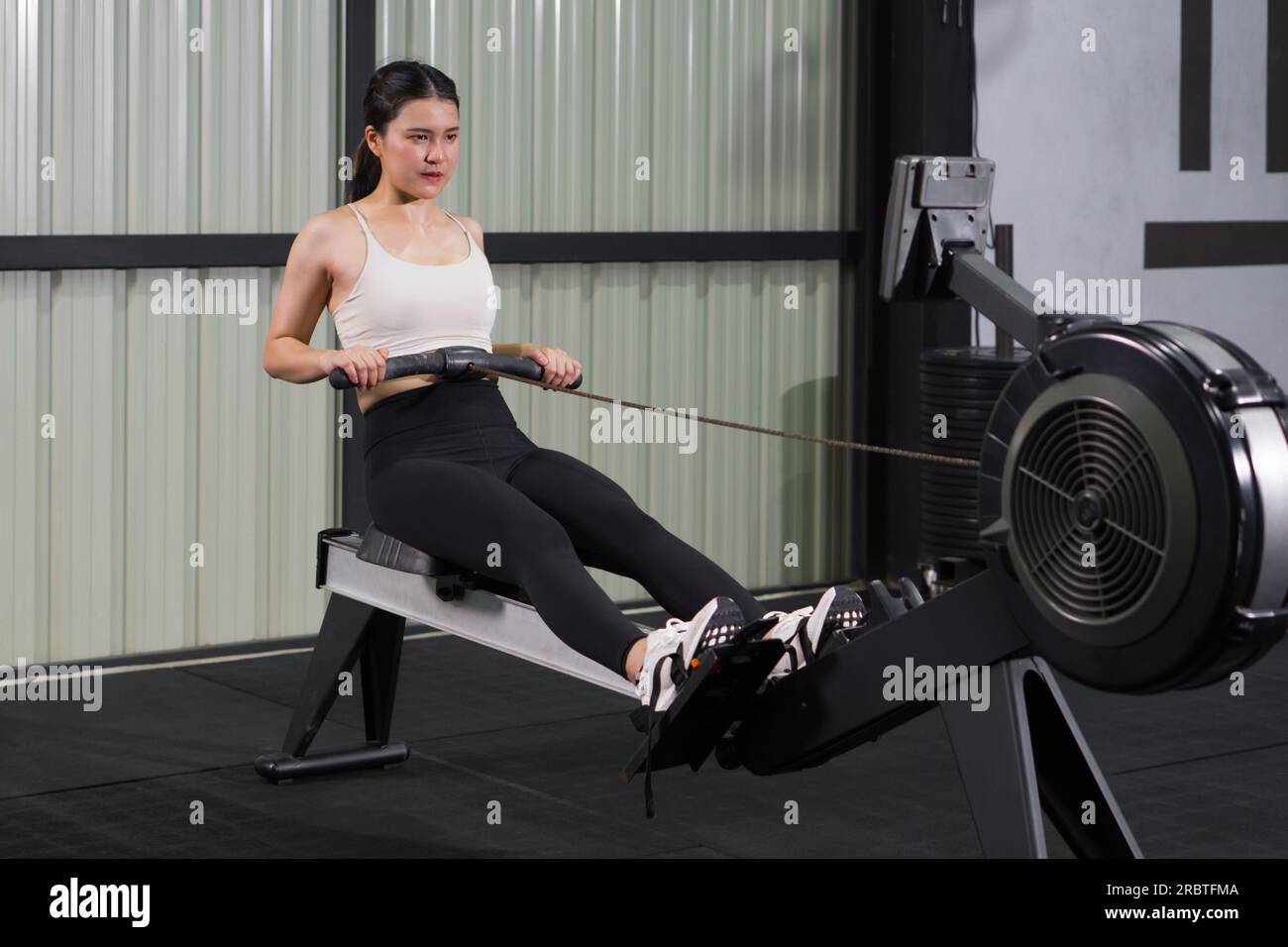 An athletic woman in sportswear is engaged in an intense workout ...