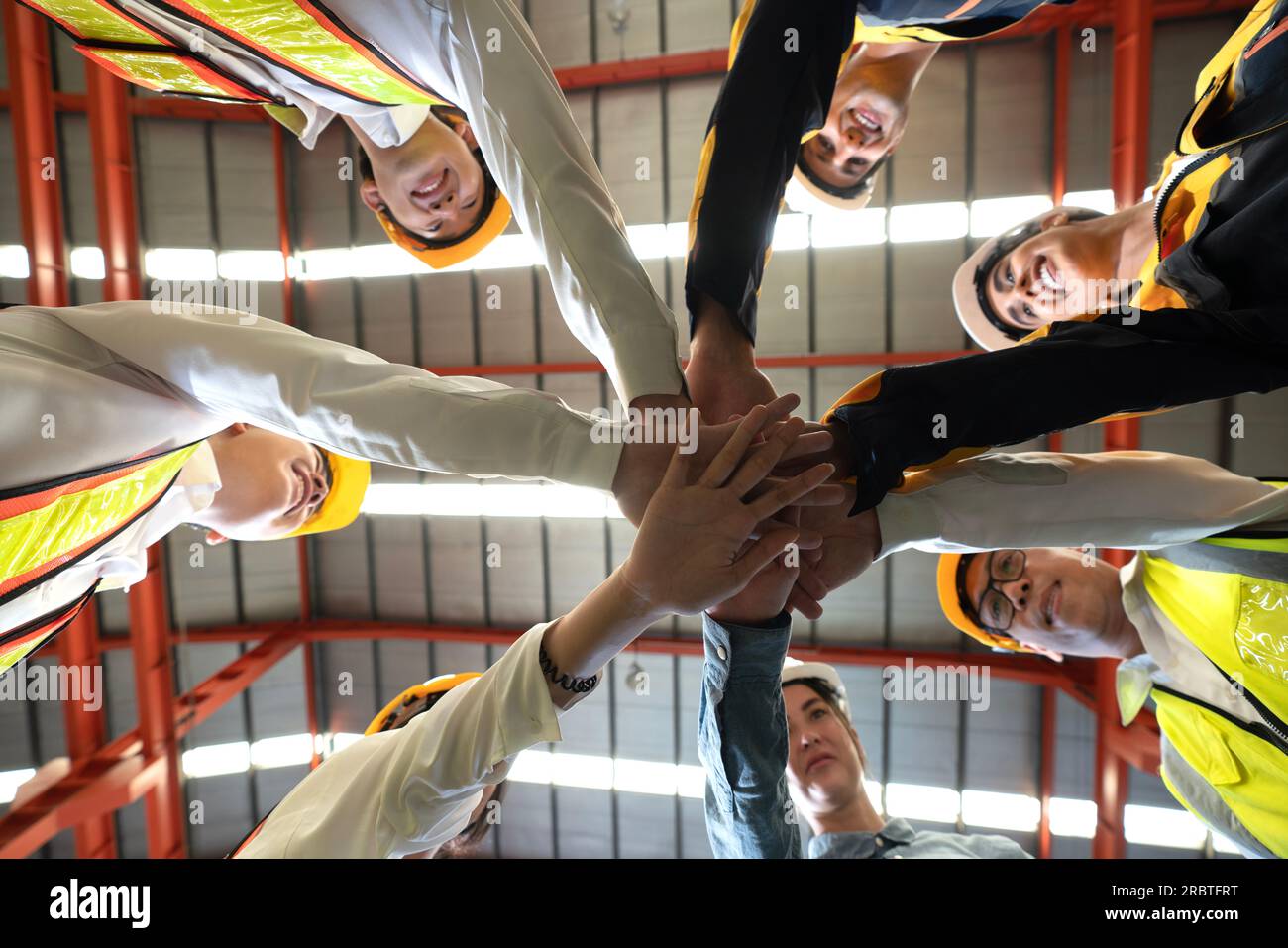 Group of male and female factory labor join hands together after finish ...