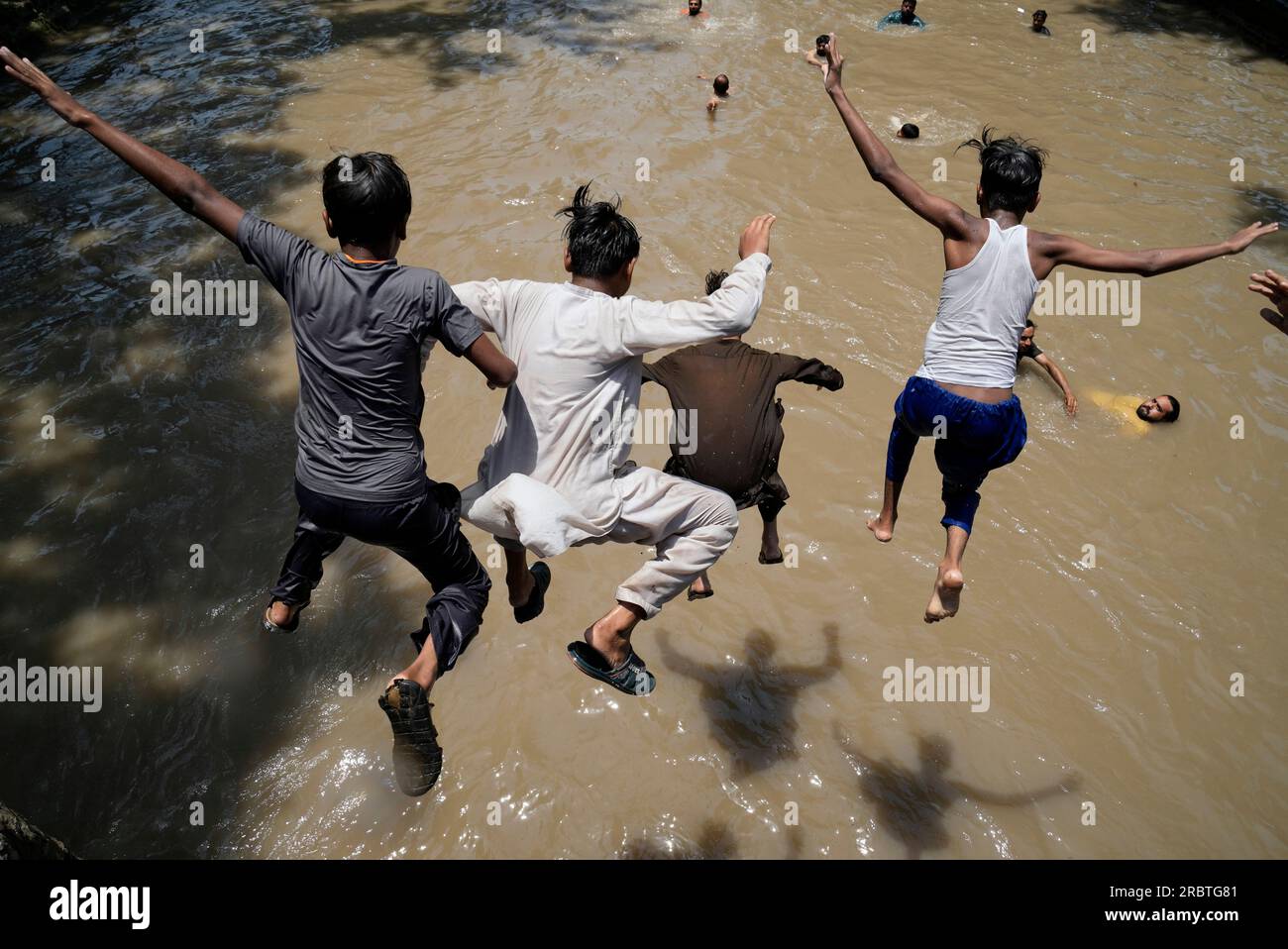 Pakistani youths jump into a canal to beat the heat in Lahore, Pakistan ...