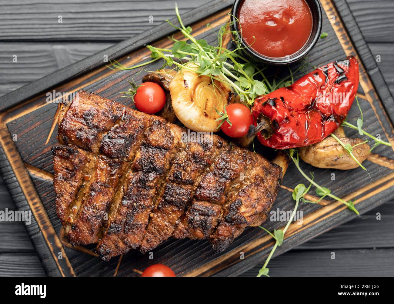 Grilled pork bbq ribs served with cherry tomatoes, pepper and barbeque ...