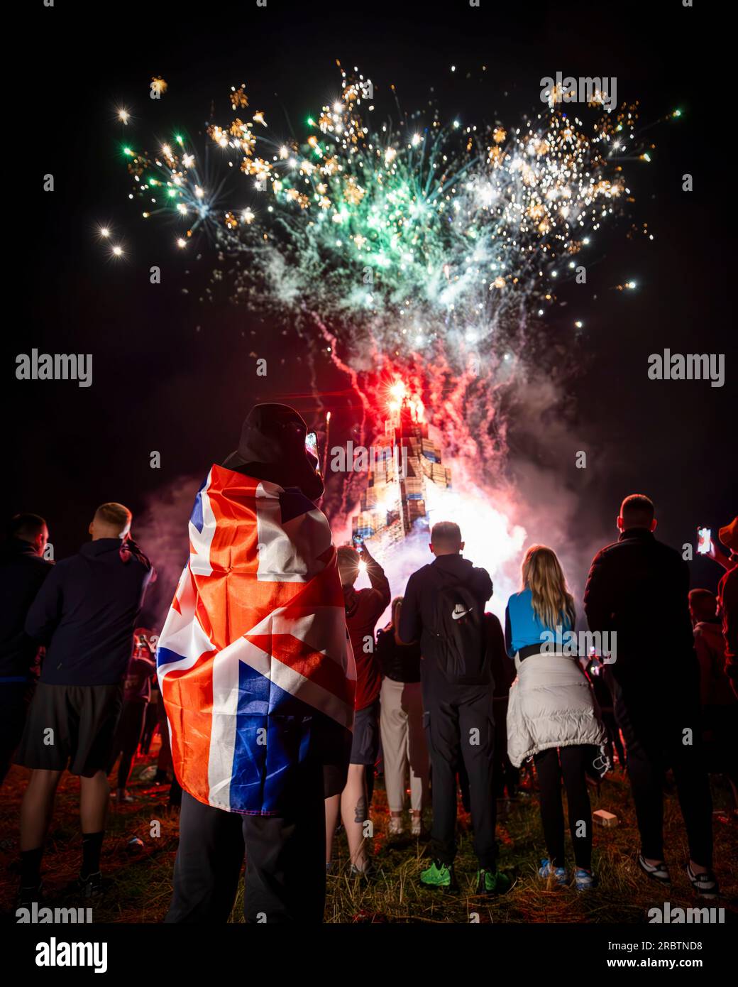 People watch the burning of the loyalist Corcrain bonfire in Portadown ...