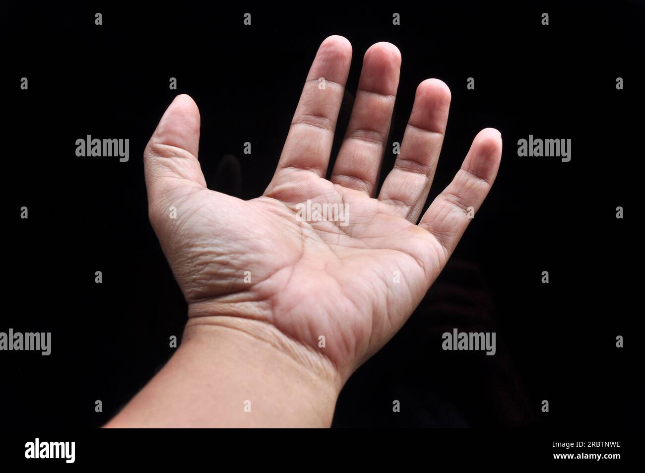 Asian man palms wide open fingers black background Stock Photo - Alamy
