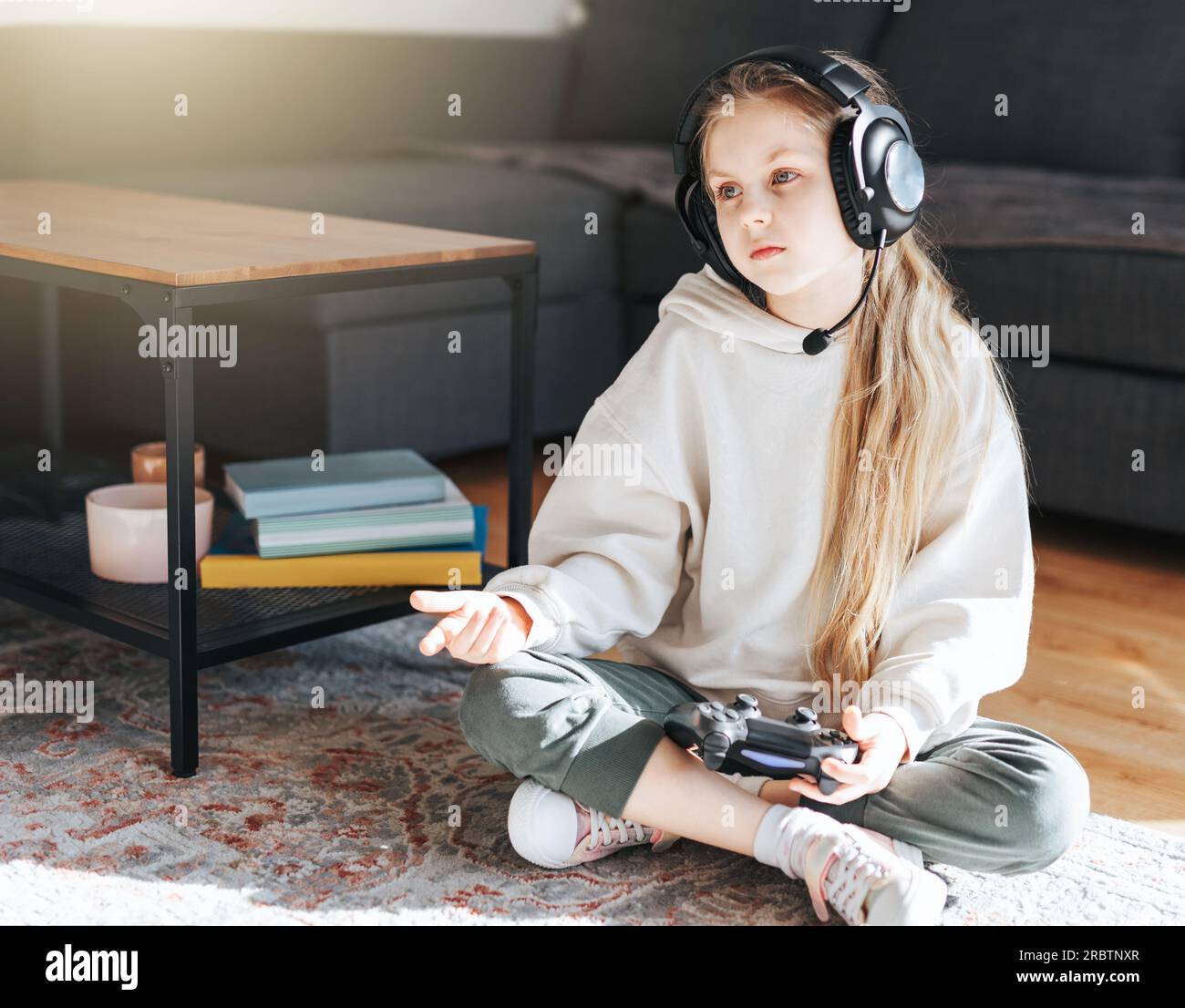 A little girl holding game controller playing video games Stock Photo ...