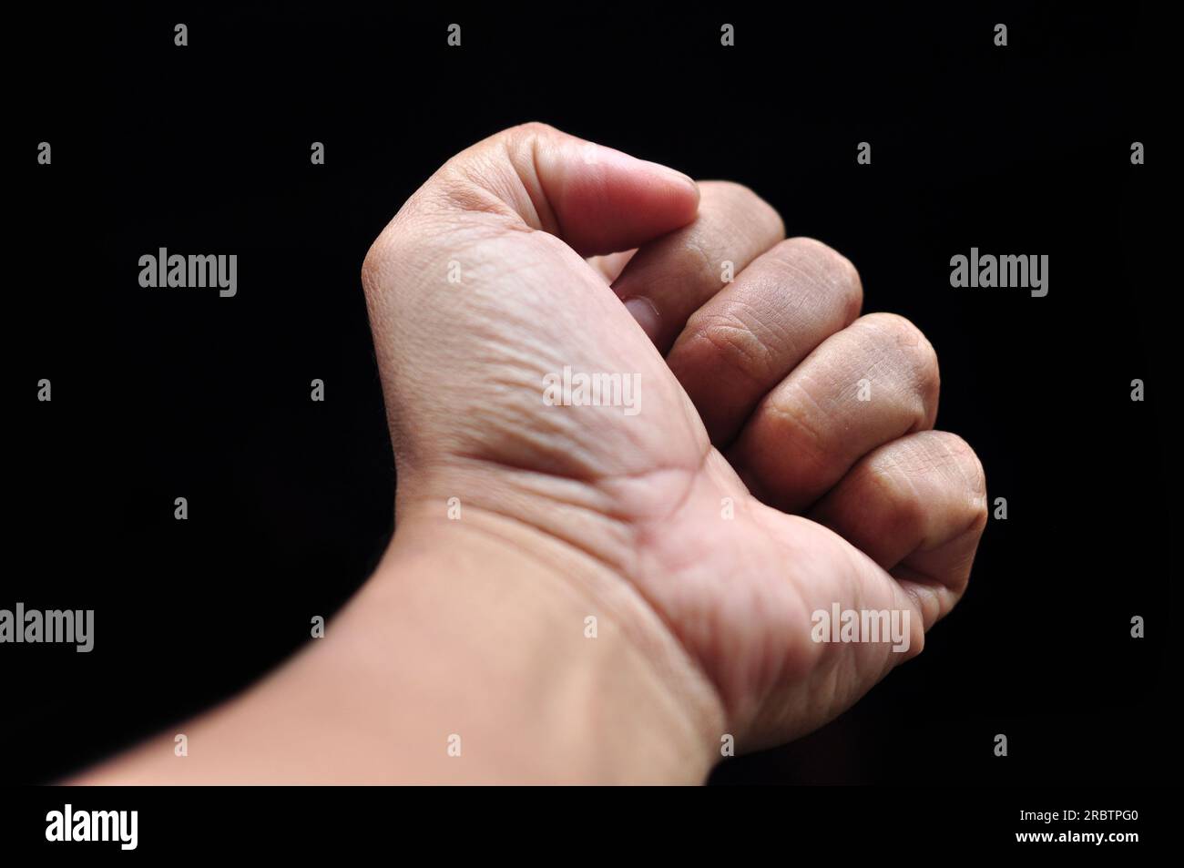 Selective focus photo of left hand clenched on black background Stock ...