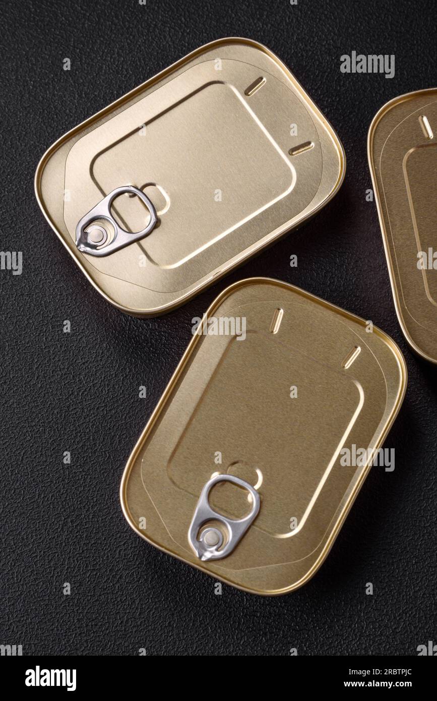 Tin or aluminum rectangular can of canned food with a key on a dark ...
