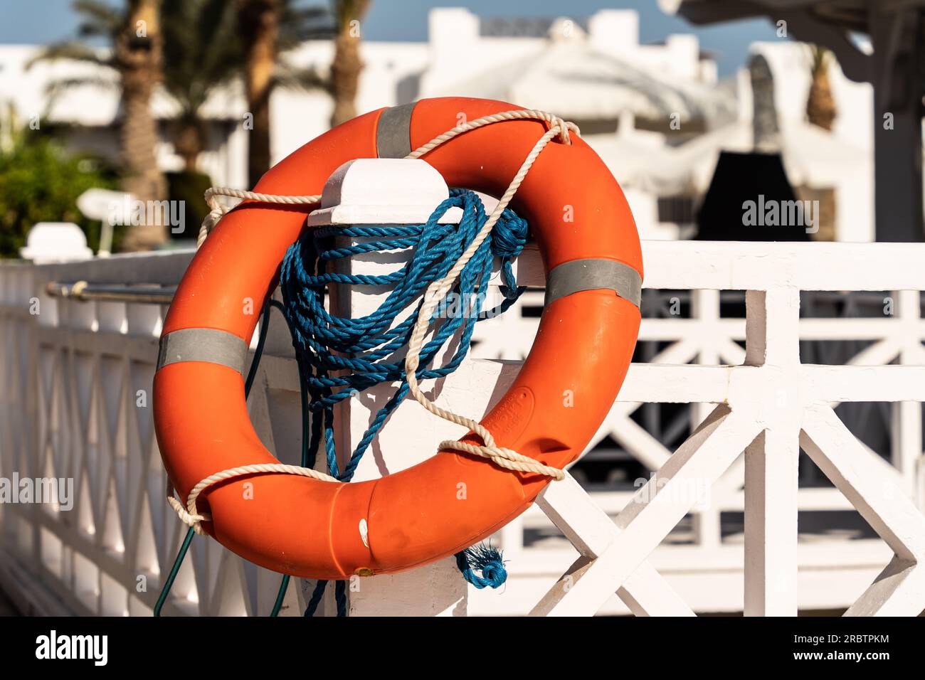 orange life buoy, safety near swimming pool, lifesaver, blue ropes Stock Photo - Alamy
