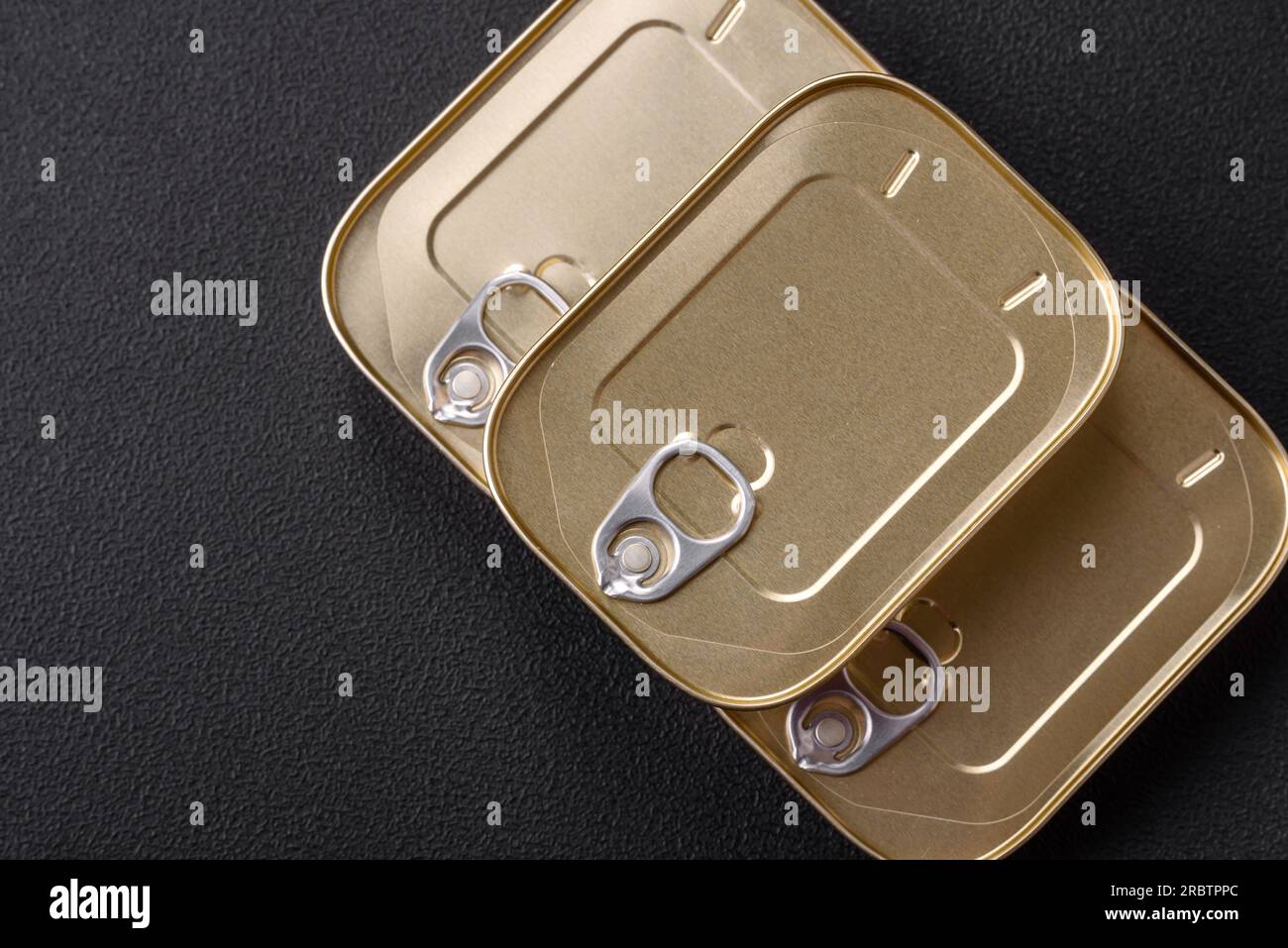 Tin or aluminum rectangular can of canned food with a key on a dark ...