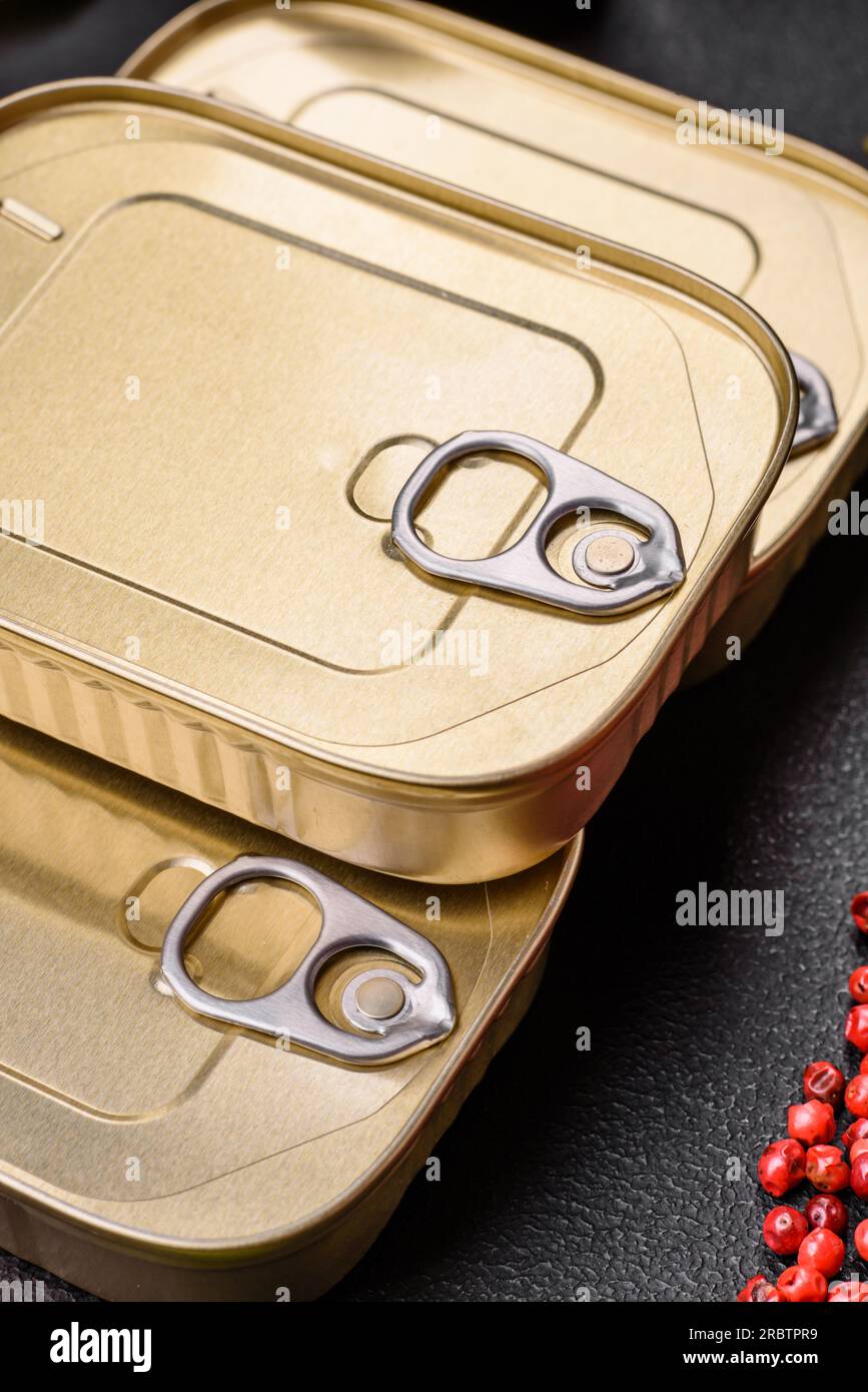 Tin or aluminum rectangular can of canned food with a key on a dark ...