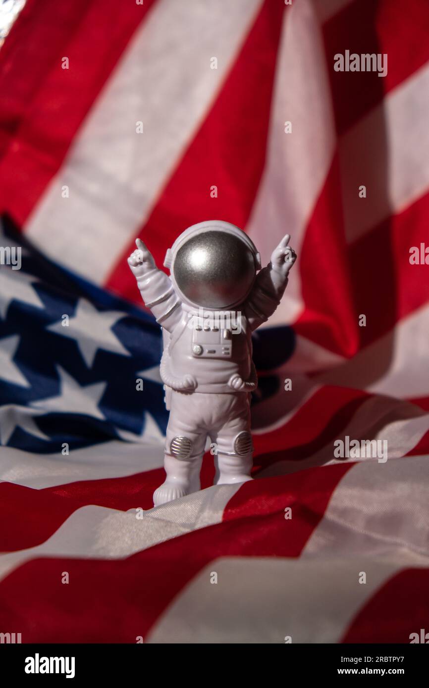 Plastic toy figure astronaut on American flag background Copy space ...