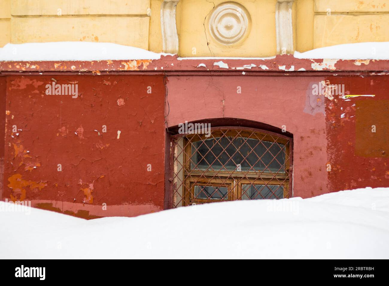 Basement window with grating covered with a large layer of snow in ...