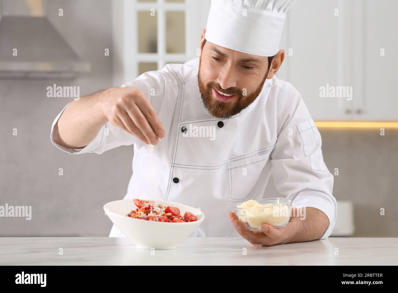 Professional chef adding grated cheese into delicious spaghetti at ...