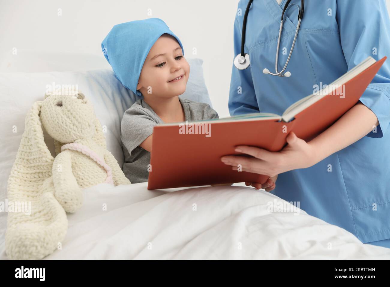 Childhood cancer. Doctor and patient reading book in hospital Stock ...