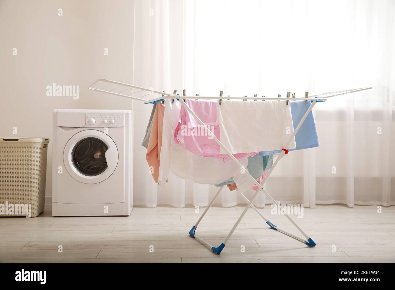 Clean laundry hanging on drying rack indoors Stock Photo - Alamy