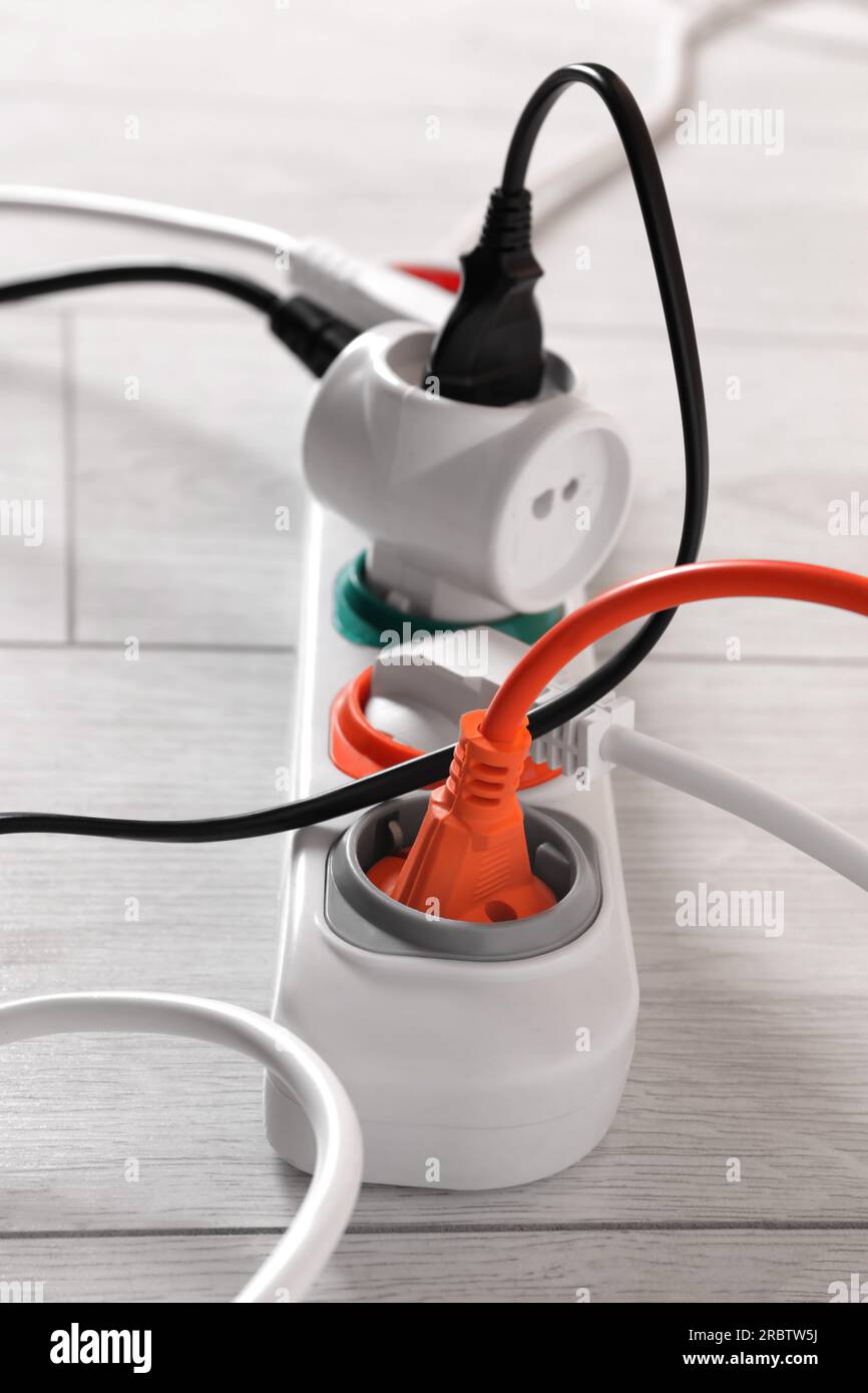 Power strip with different electrical plugs on white laminated floor ...