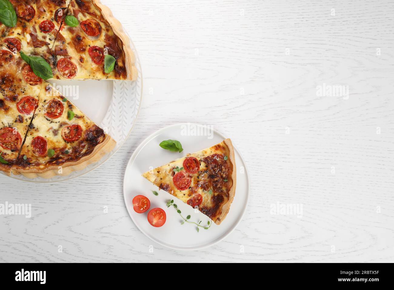 Cut delicious homemade quiche with prosciutto, tomatoes and basil on ...