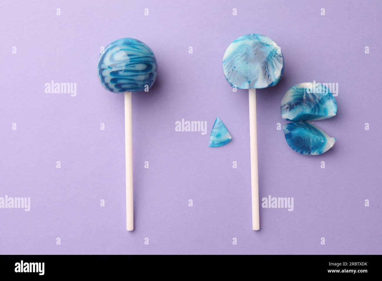 Whole and broken lollipops on violet background, flat lay Stock Photo ...