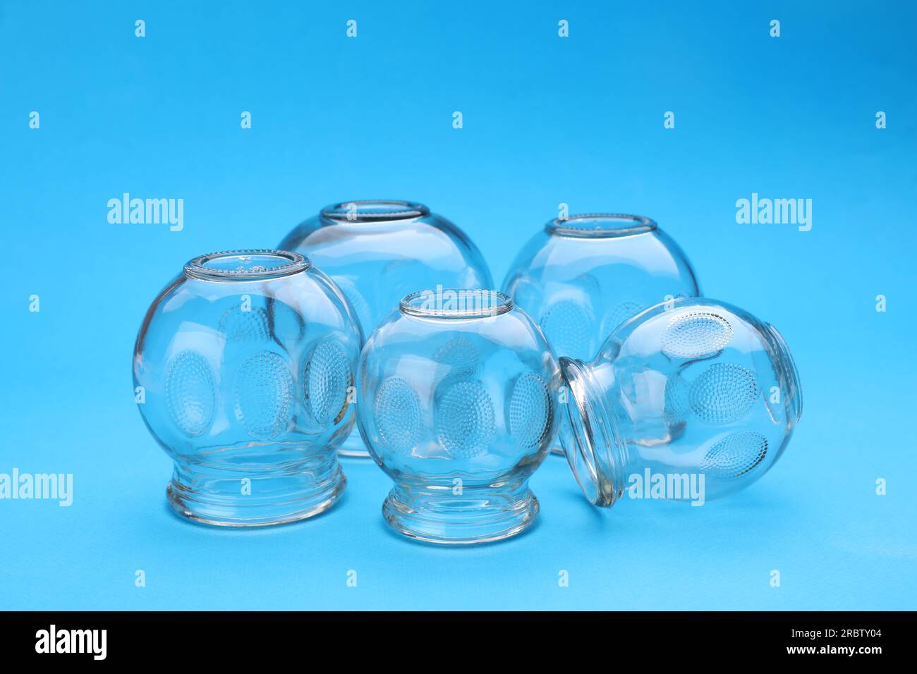 Glass cups on light blue background. Cupping therapy Stock Photo - Alamy