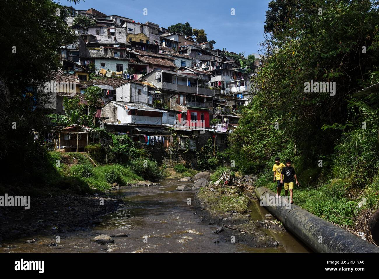 Bandung, West Java, Indonesia. July 11, 2023 A child crosses a river in ...
