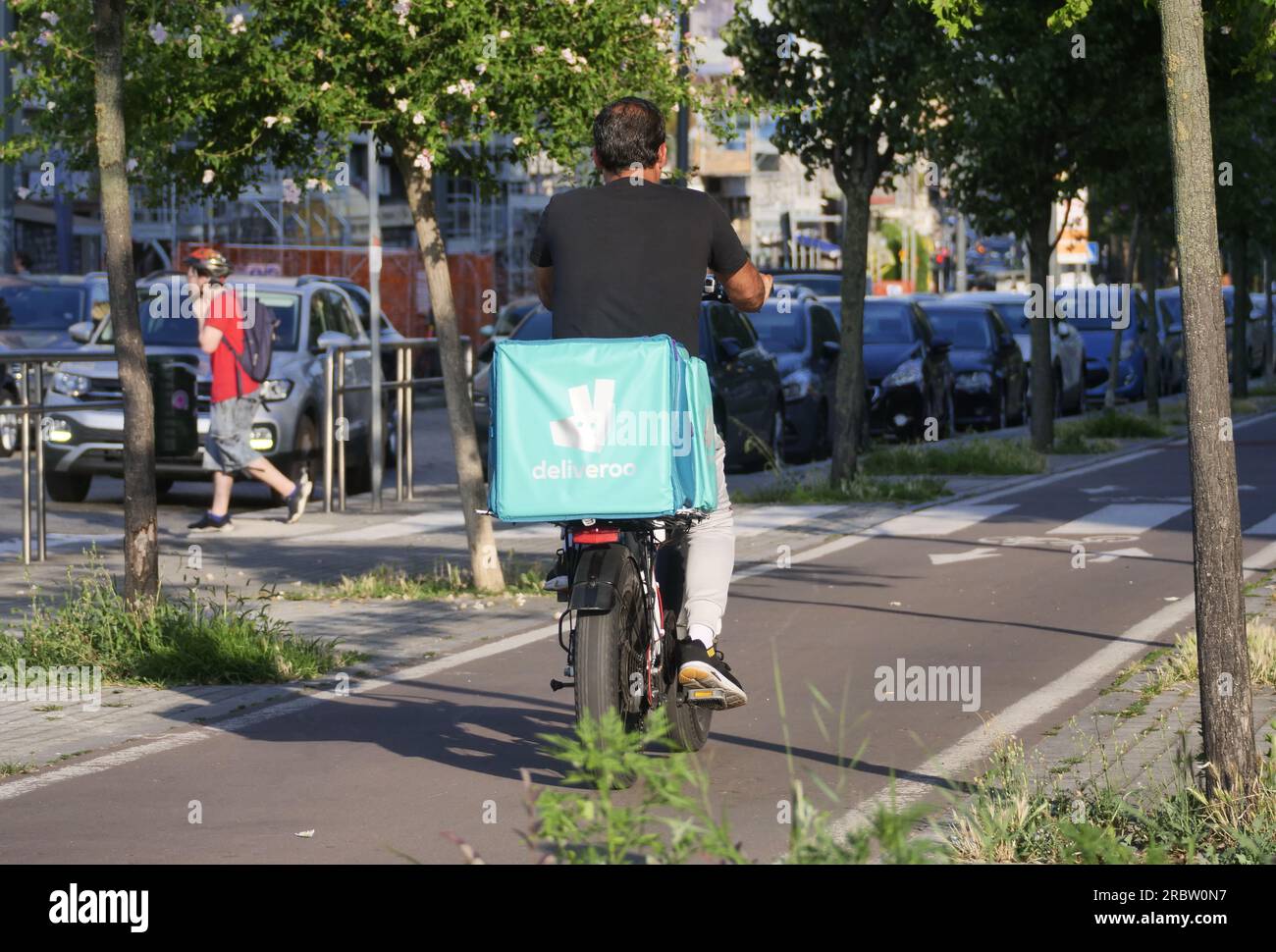 Bicycle food delivery rider working in the street of Milan before ...