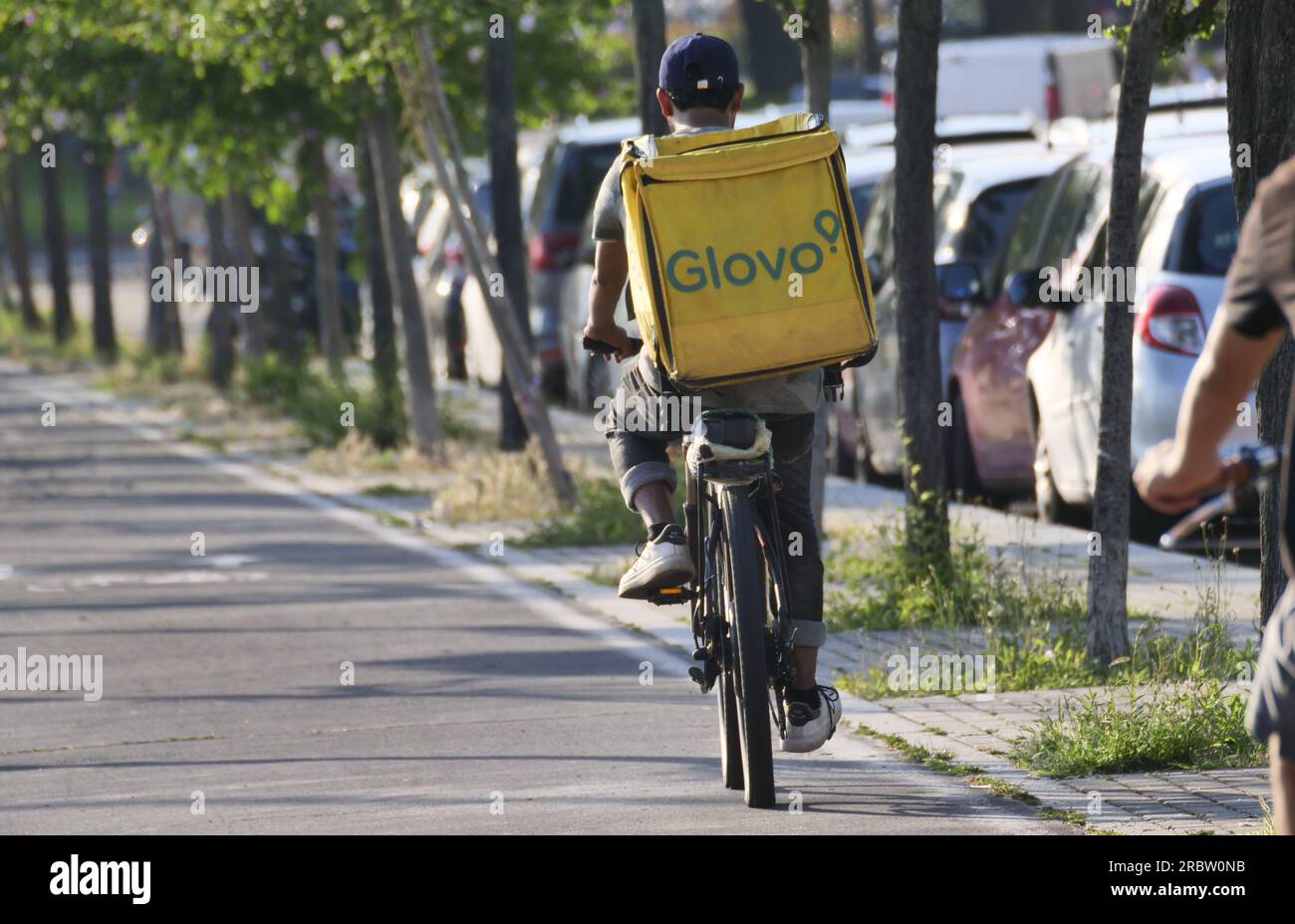 Bicycle food delivery rider working in the street of Milan before ...
