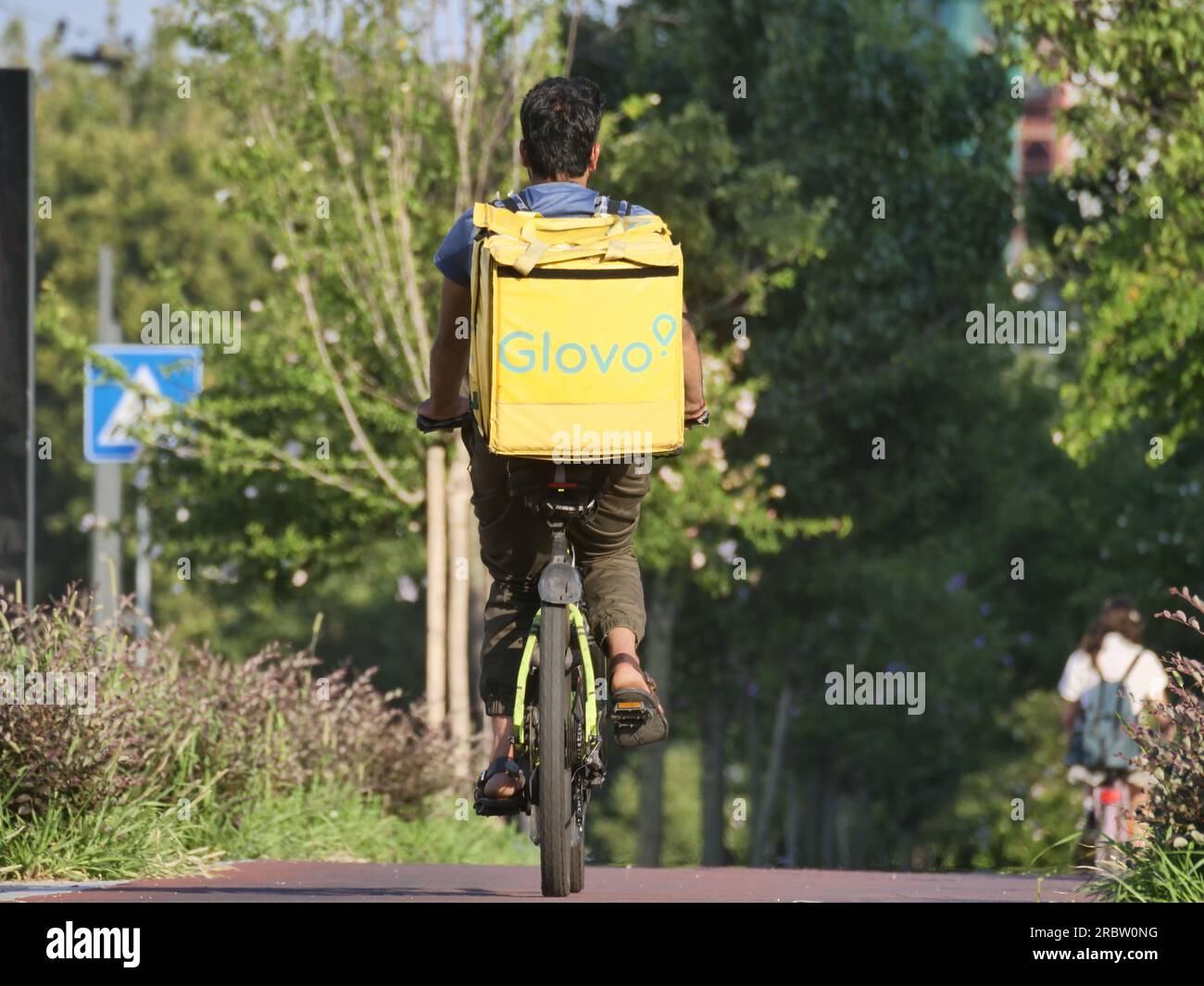 Bicycle food delivery rider working in the street of Milan before ...