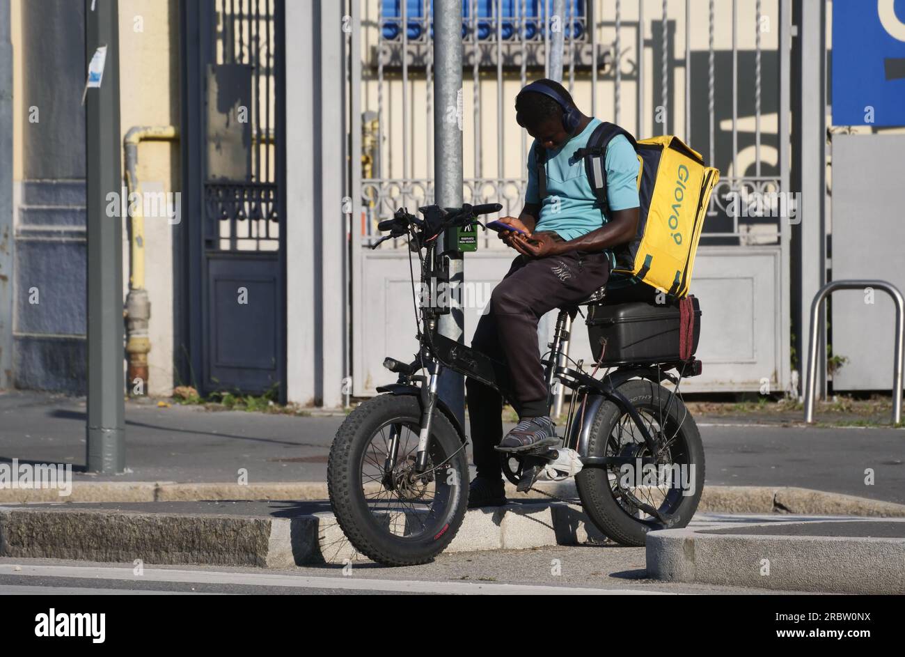 Bicycle food delivery rider working in the street of Milan before ...