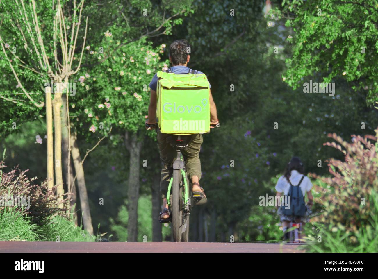 Bicycle food delivery rider working in the street of Milan before ...