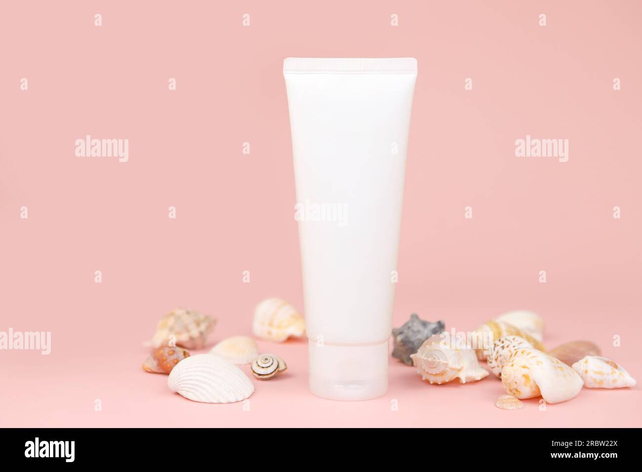 Unbranded white squeeze bottle cream tube and seashells a lot on pink ...