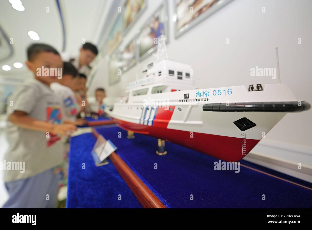 YANTAI, CHINA - JULY 11, 2023 - Children look at a model of a beacon ...