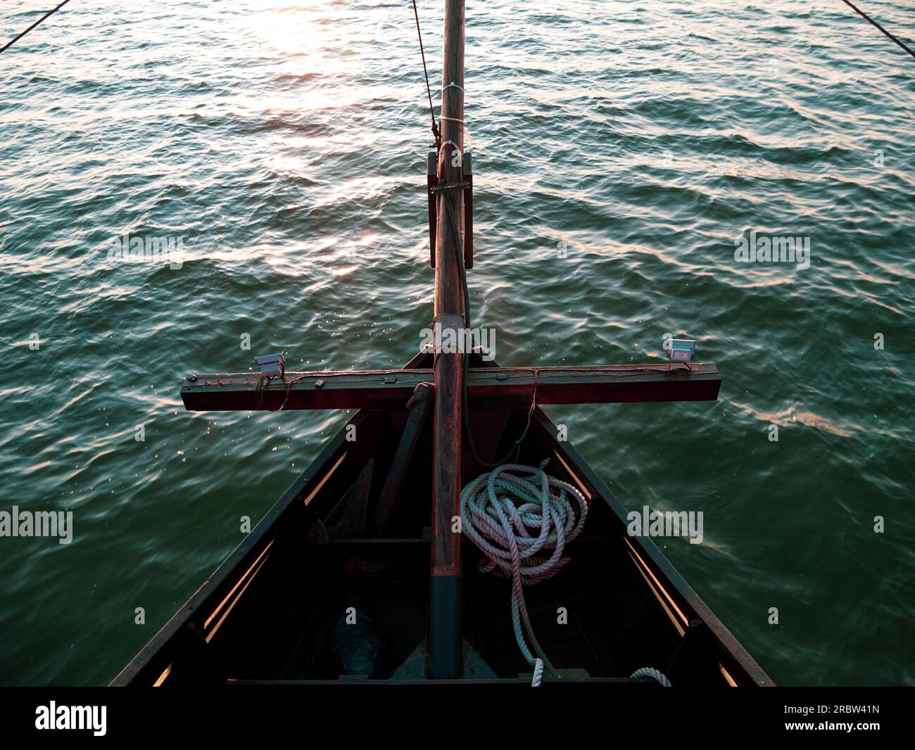 Sailboat bow with mooring rope sailing on the sea waves with turquoise ...